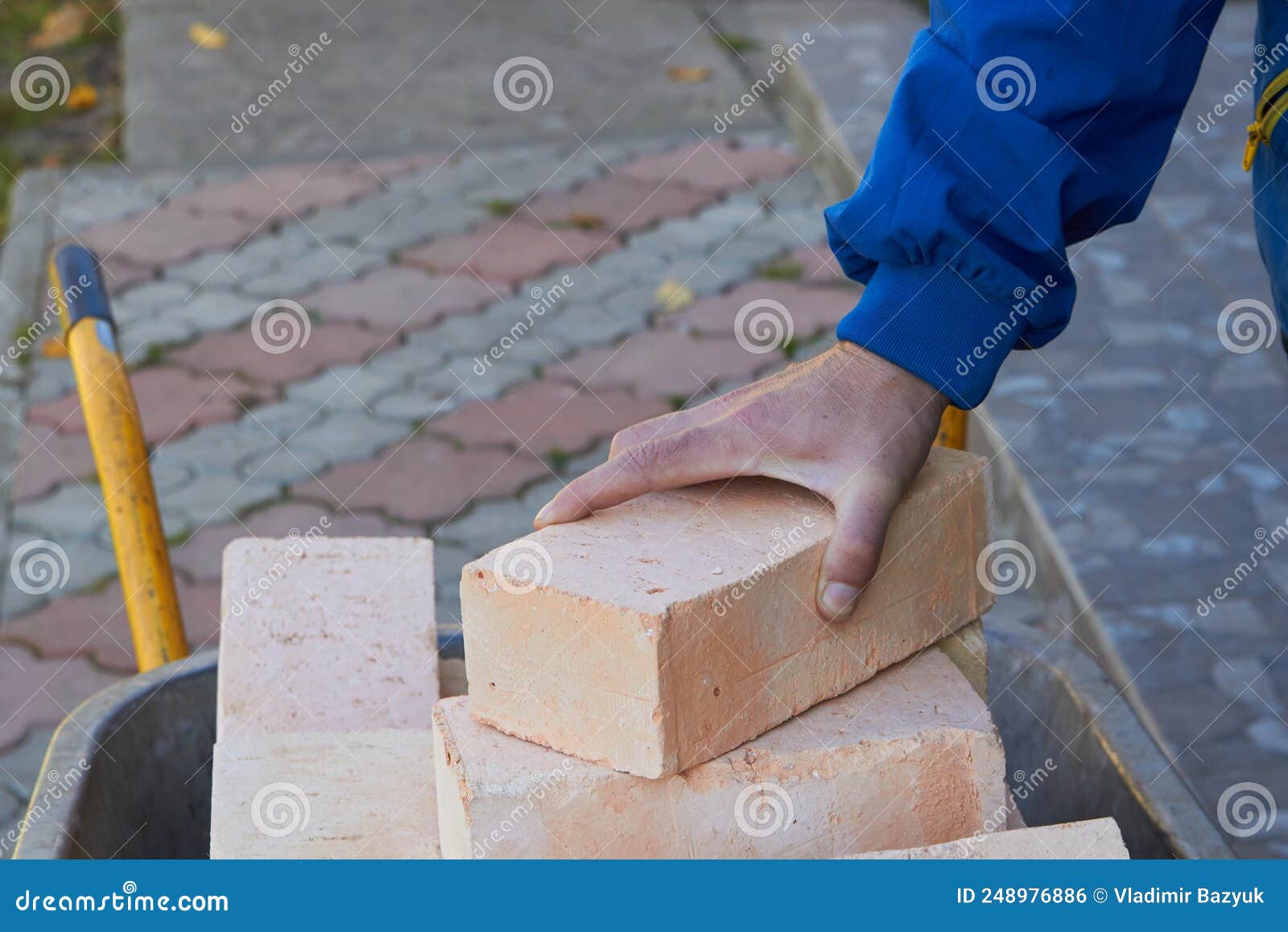 Hand Takes a Brick,builder Takes a Brick by Hand from a Wheelbarrow ...