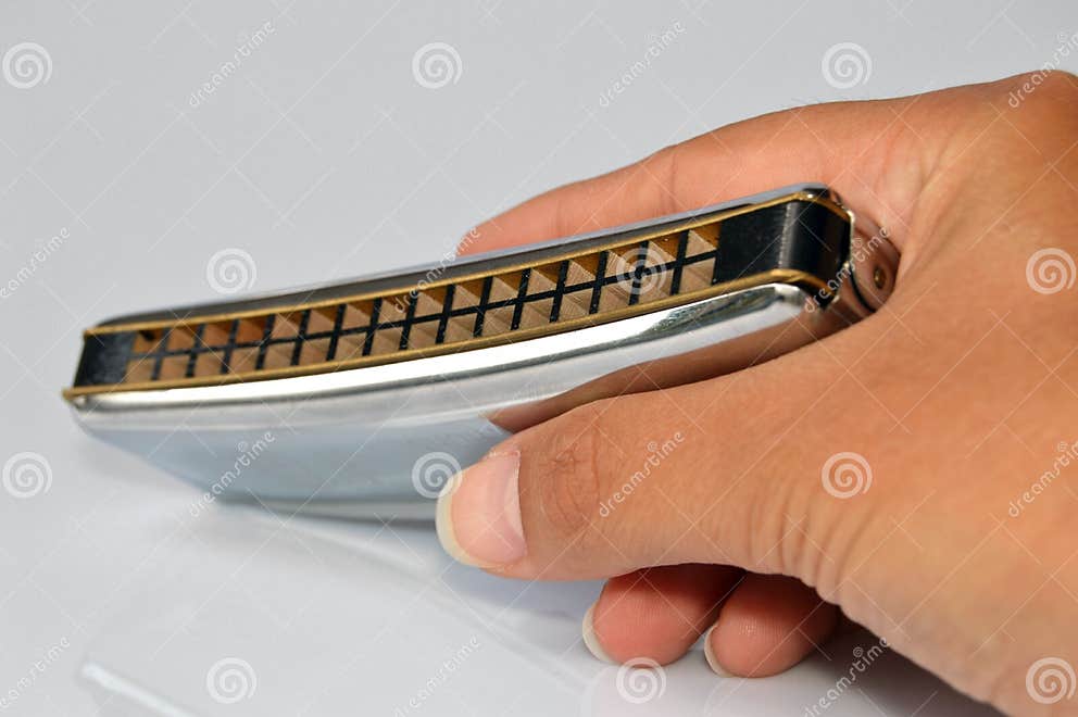 Hand taking a harmonica stock image. Image of musician - 58790865