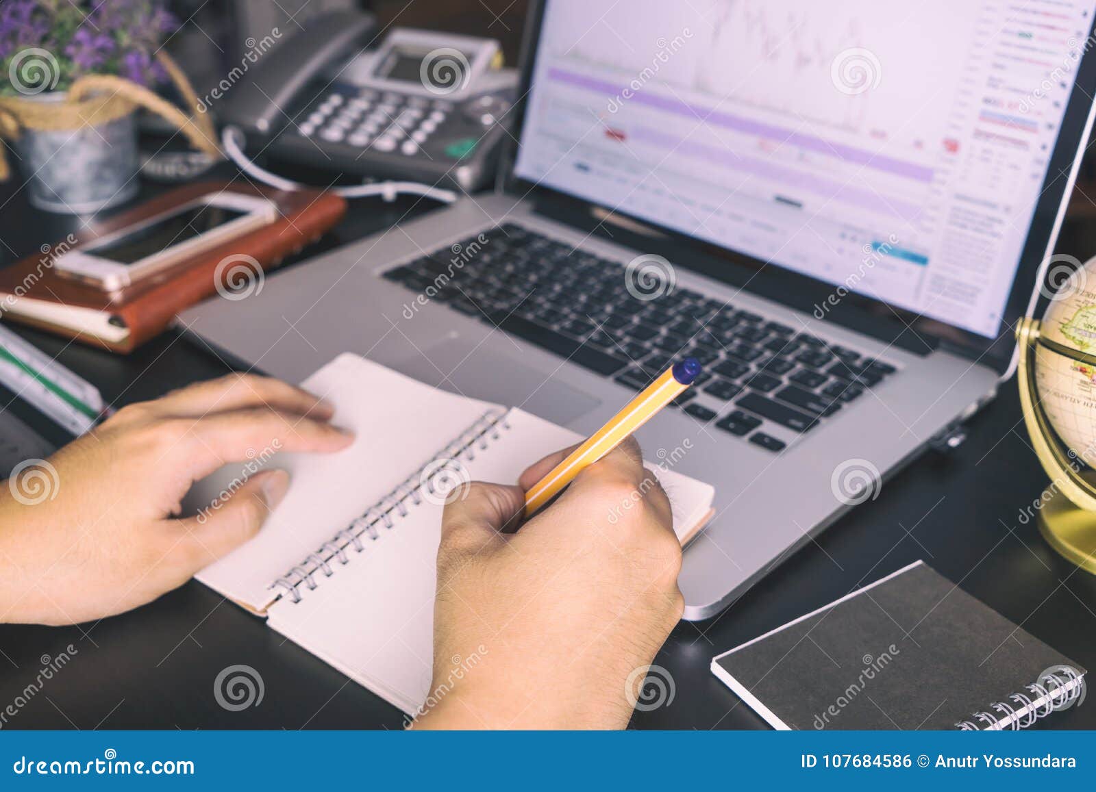 Hand Taking Note from Stock Trading Data on Computer Stock Photo ...