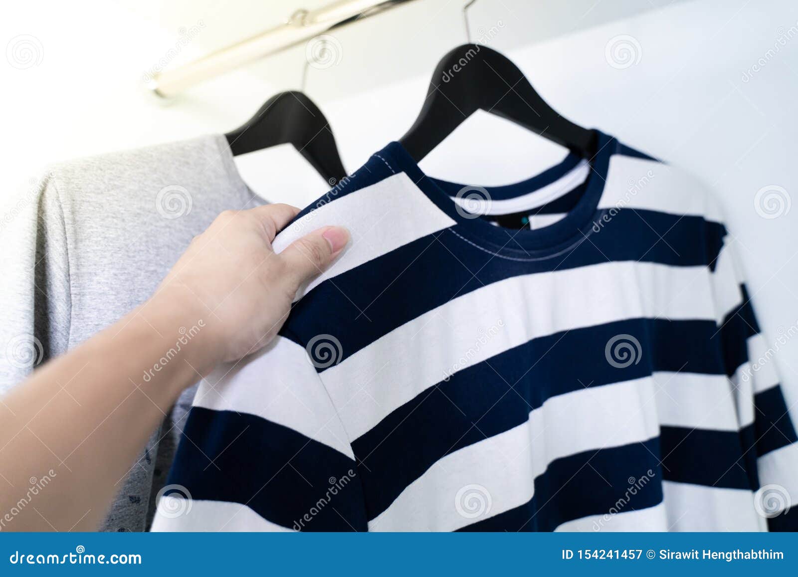 A Hand Taking a Shirt, Shirts Hanging in a Row Editorial Photography ...