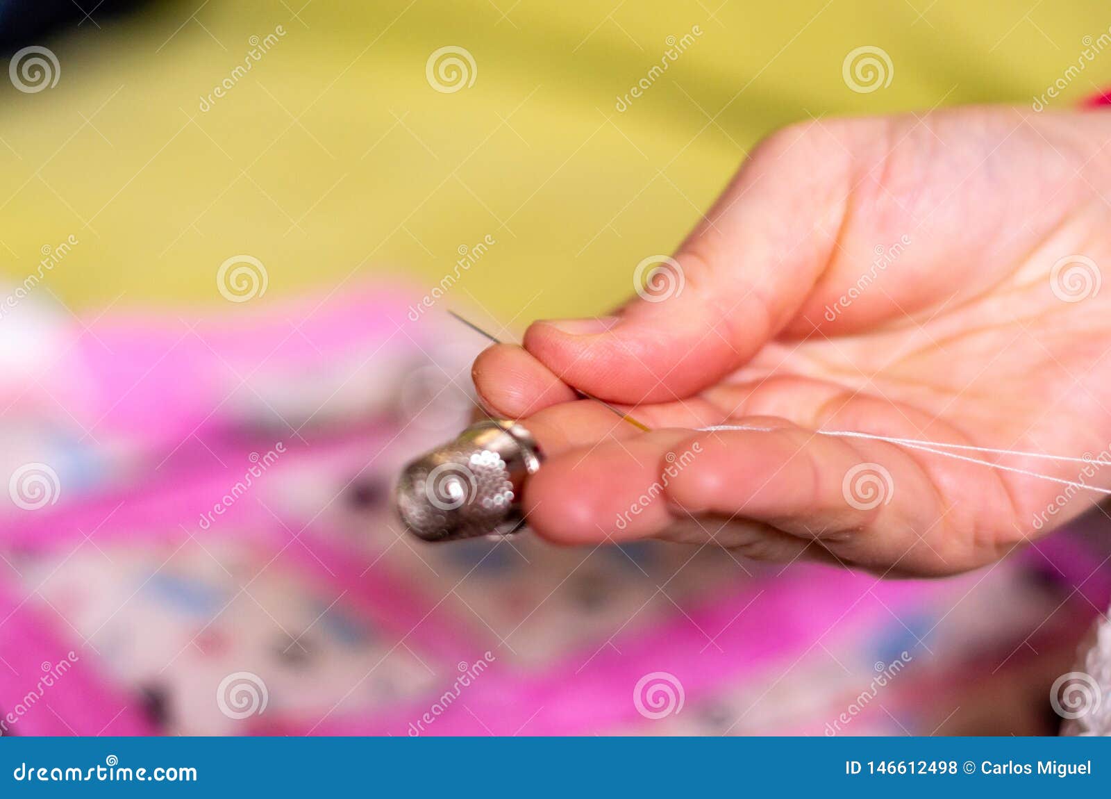 A Hand with Thimble Knotting and Cutting a Thread on a Needle in a ...