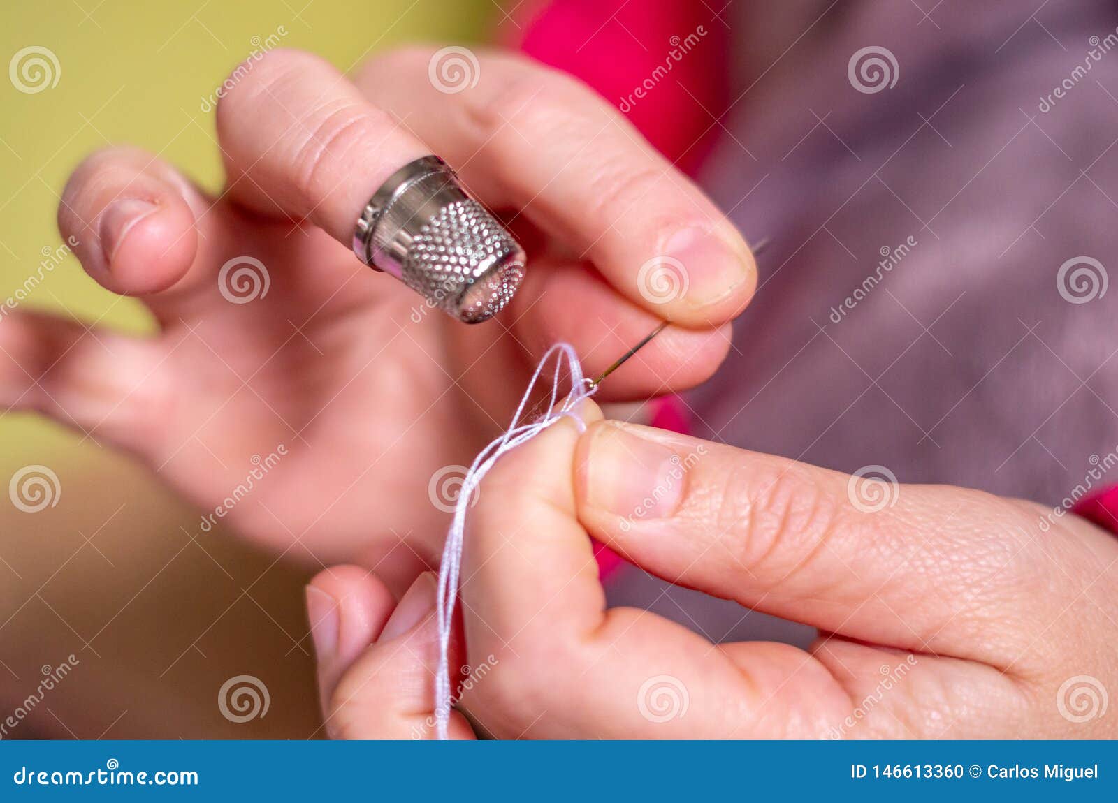 A Hand with Thimble Knotting and Cutting a Thread on a Needle in a ...
