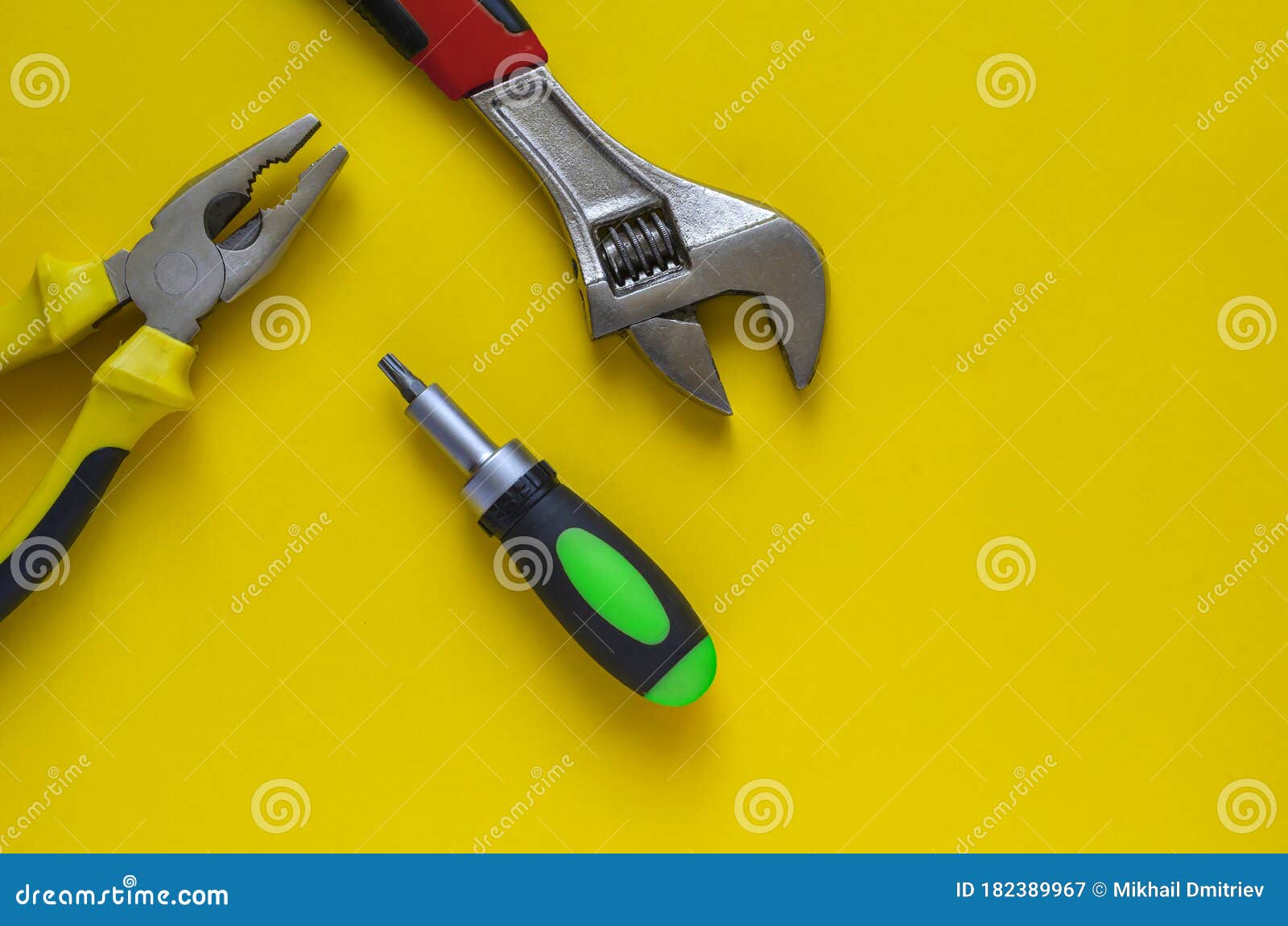 Hand Tool with Multi-colored Handles on a Yellow Background Stock Image ...