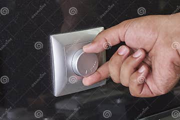 Hand Turning Down Electrical Light Dimmer Switch or Conditioner Heat ...