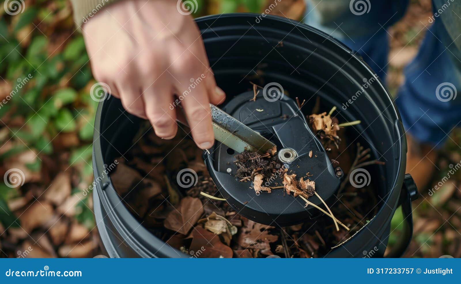 A Hand Turning the Handle on the Side of the Composter Activating the ...