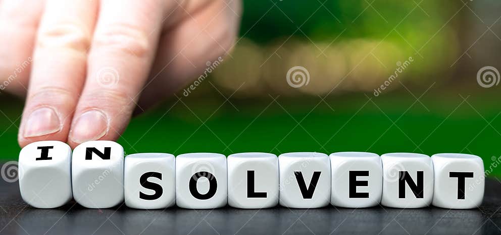 Hand Turns Dice and Changes the Word Solvent To Insolvent Stock Photo ...