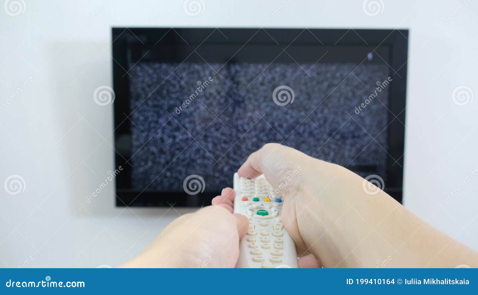 Hand with TV Remote Control in Front of the Screen with White Noise on ...