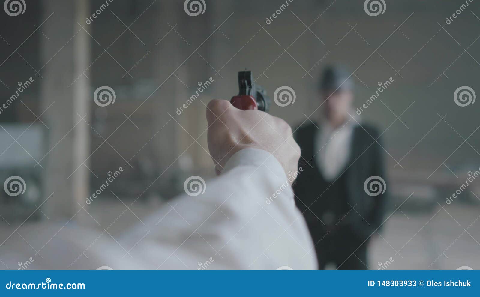The Hand of an Unrecognizable Man Aiming a Gun, Blurred Figure of a ...