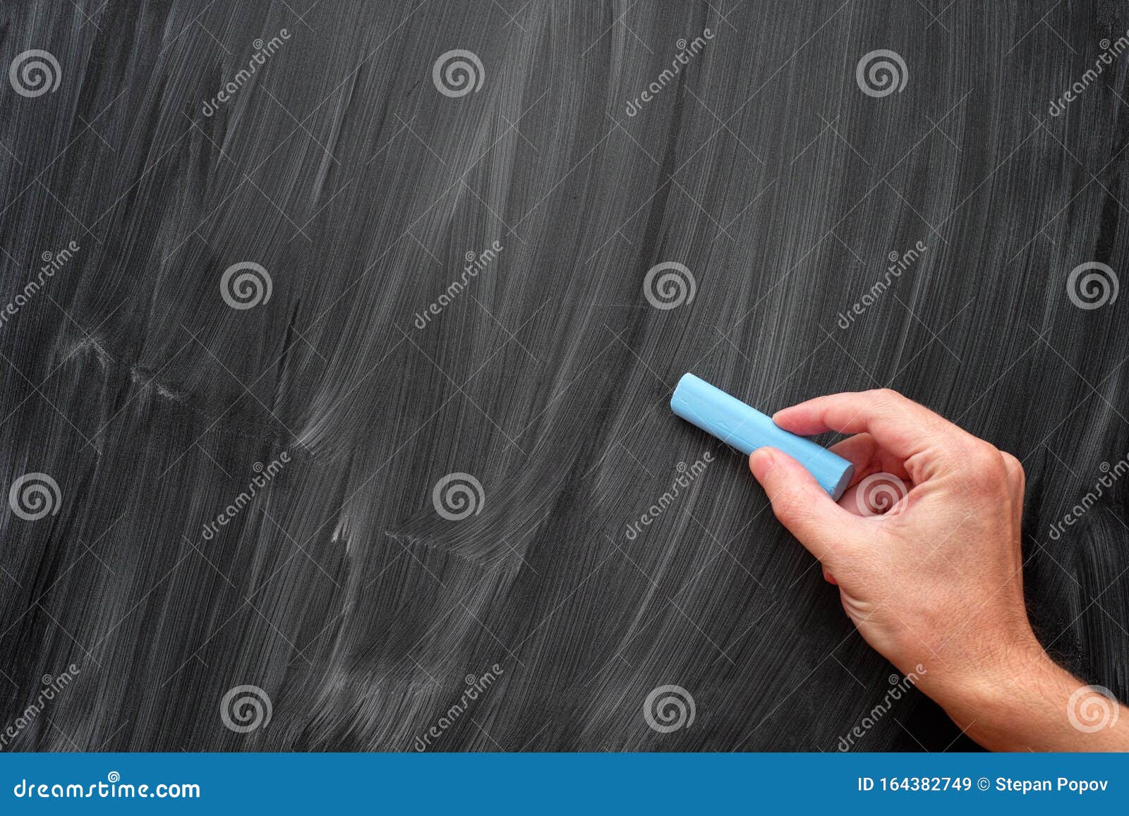 Hand Using Blue Chalk on a Black Chalkboard Stock Image - Image of ...