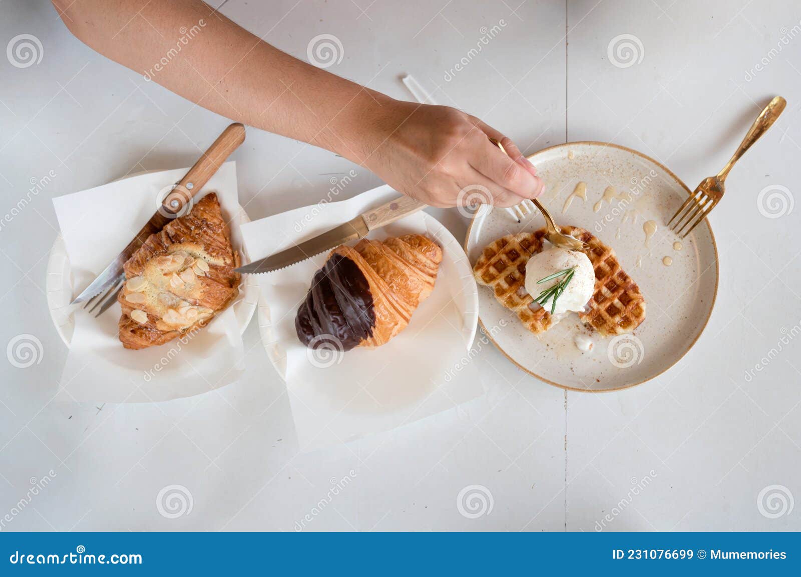 Hand Using Spoon Scooping Ice Cream Waffle and Croissant on White Table ...