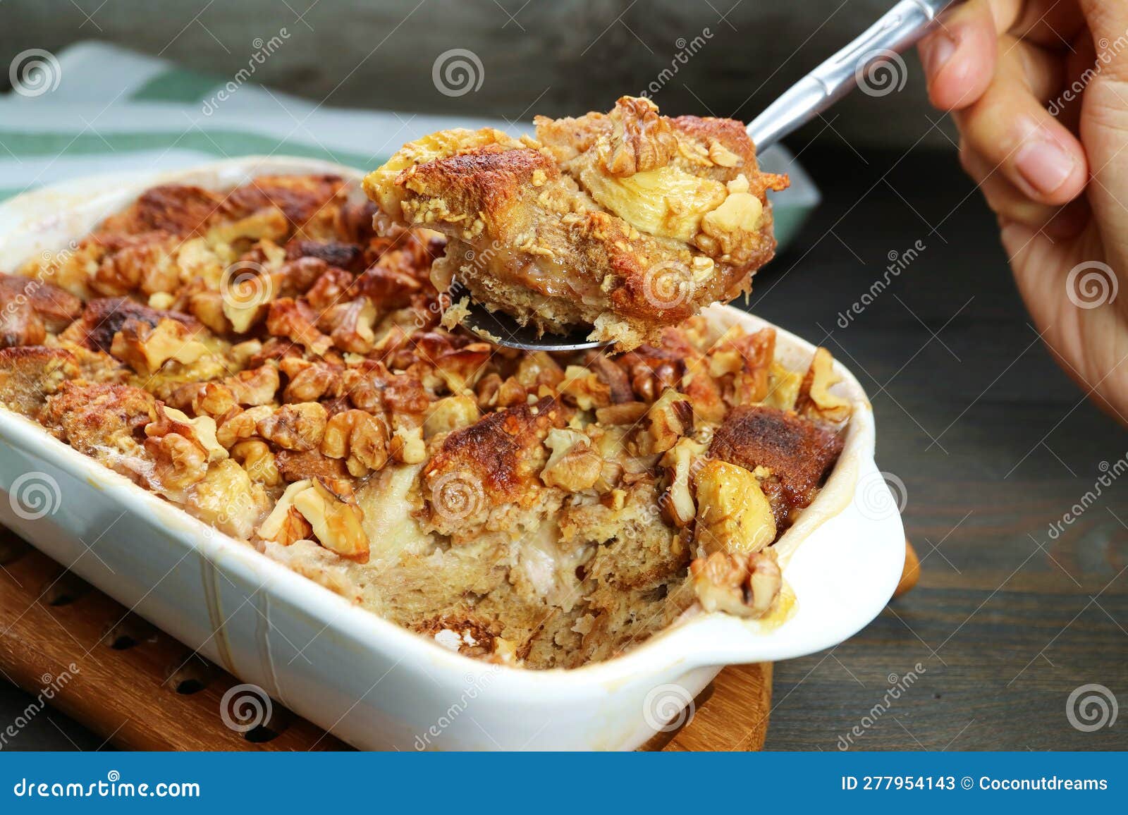 Hand Using Spoon Scooping Banana Walnut Bread Pudding from Ceramic Bowl ...