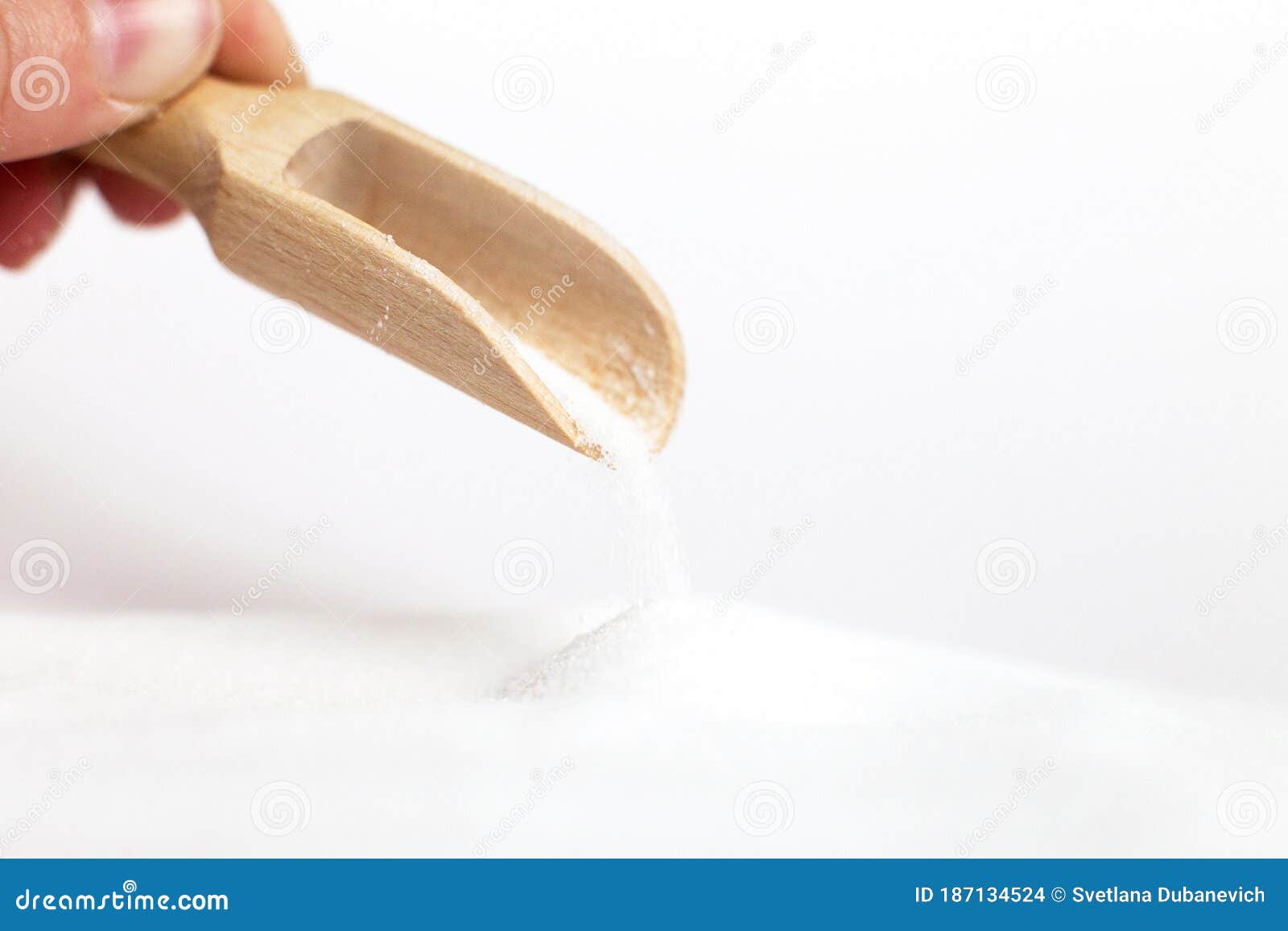 Hand with a Wooden Spoon of Salt Grain on White Background Stock Photo ...