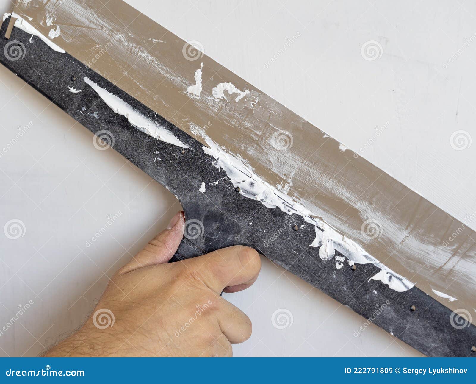 The Hand of a Worker with a Long Spatula that Works on the Wall ...