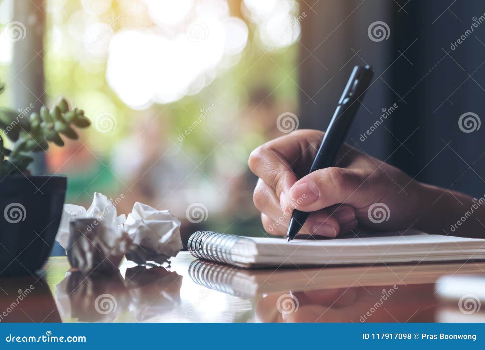 A Hand Working and Writing Down on a White Blank Notebook with Screwed ...