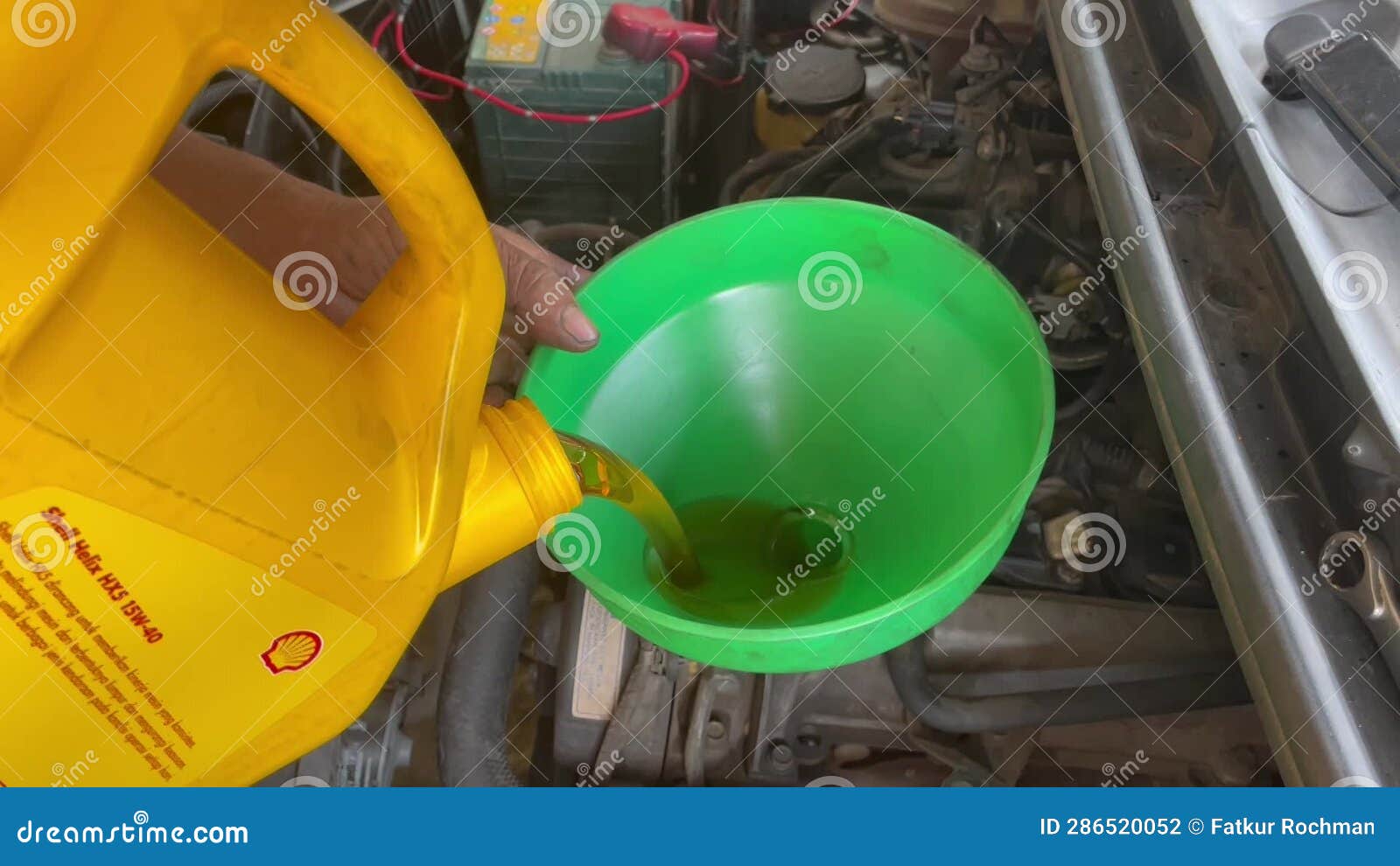 The Hand of a Workshop Worker Pouring Oil Using a Funnel for Servicing ...