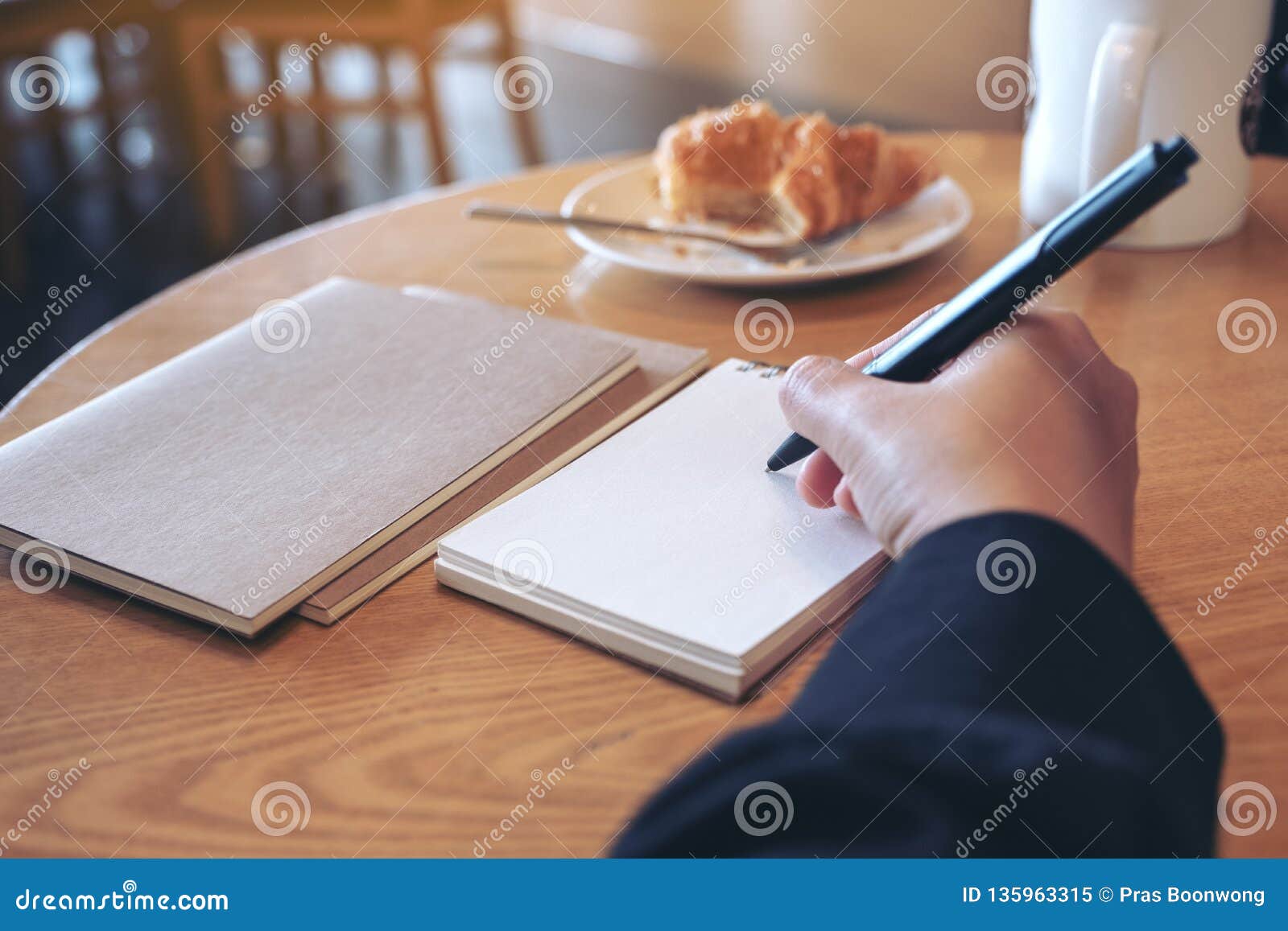 A Hand Writing on Blank Notebook with Coffee Cup and Croissant on Table ...
