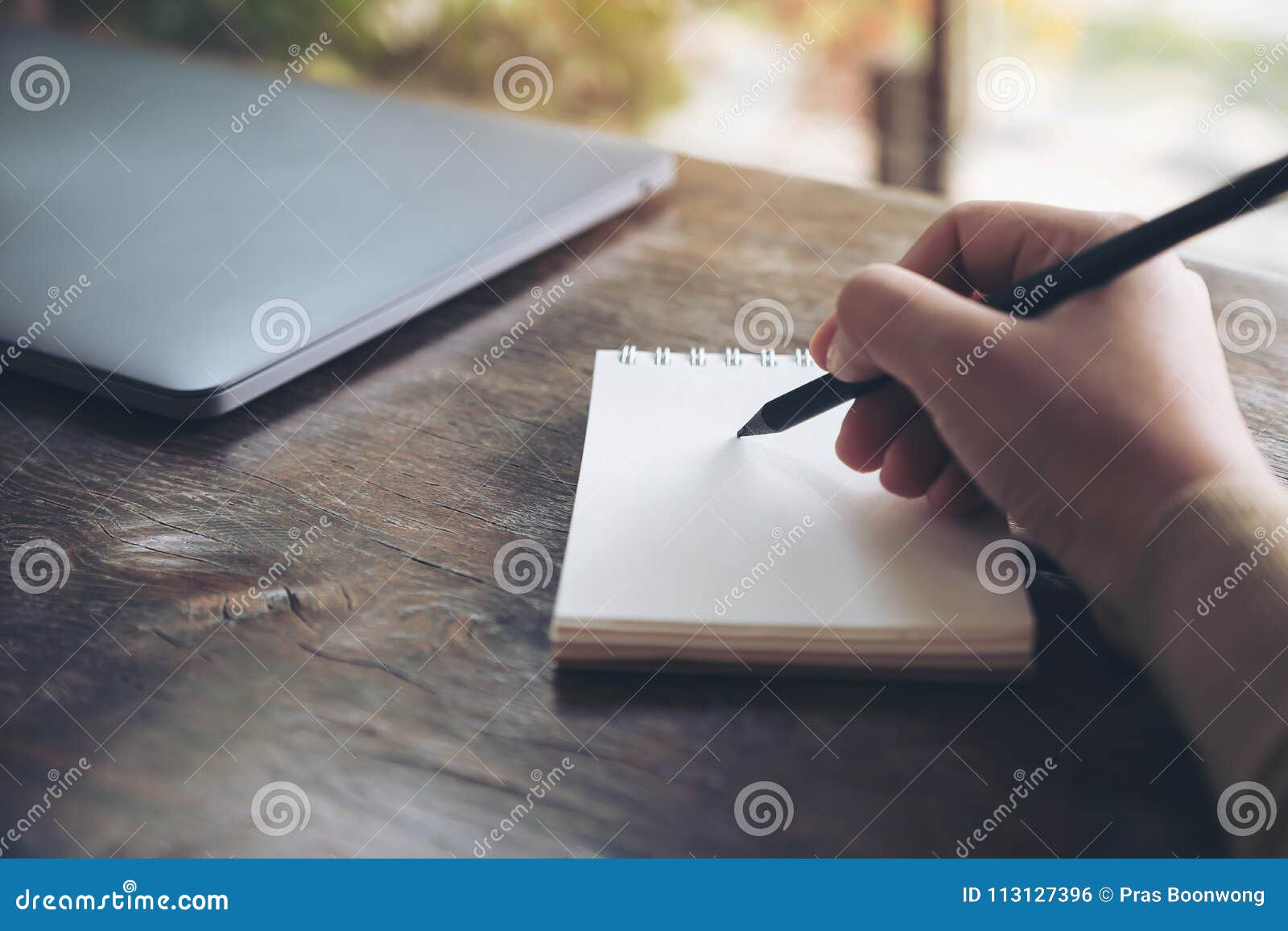 Hand Writing Down on a Blank Notebook with Laptop on Wooden Table Stock ...