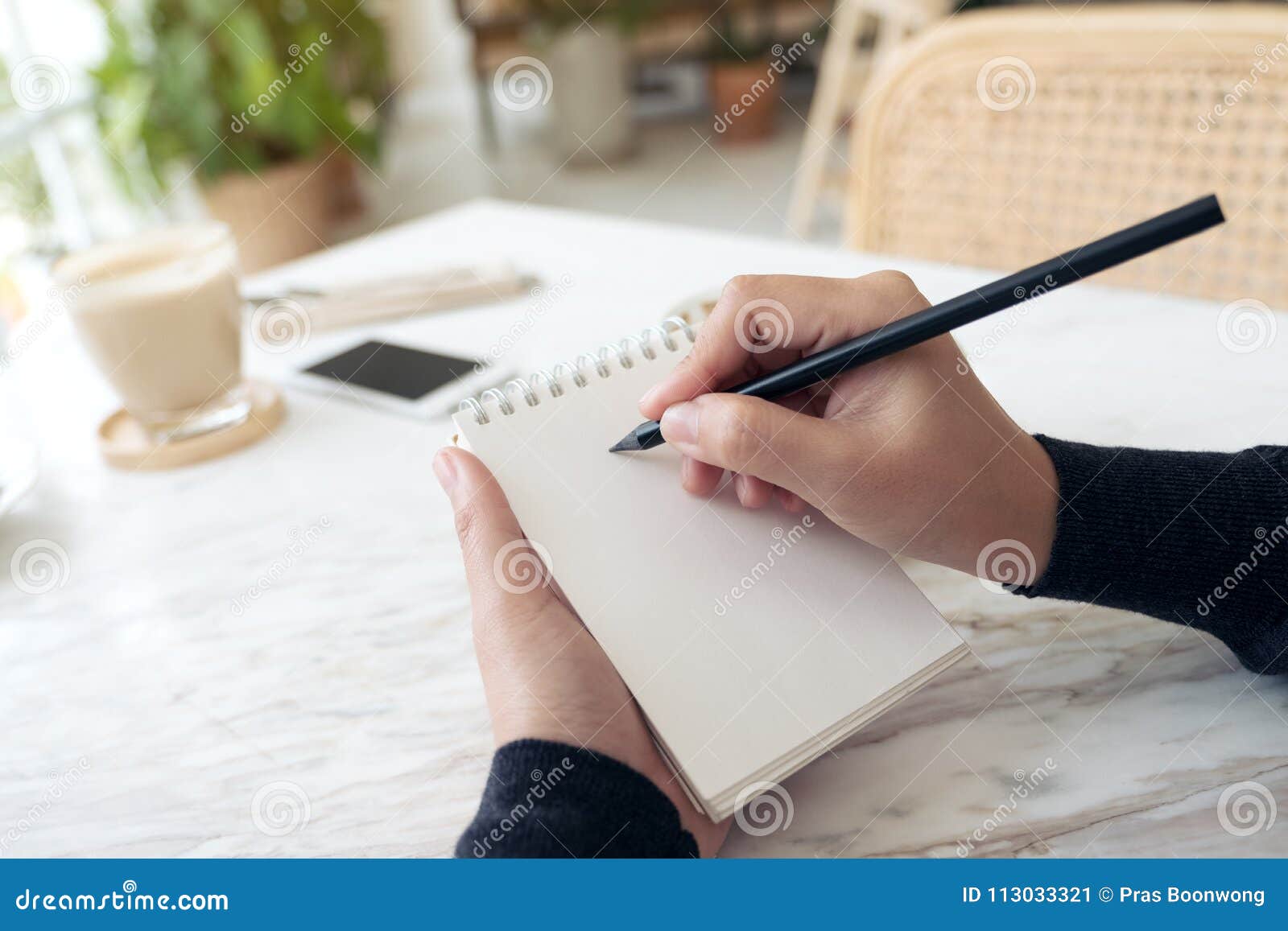 A Hand Writing Down on a White Blank Notebook with Coffee Cup and ...