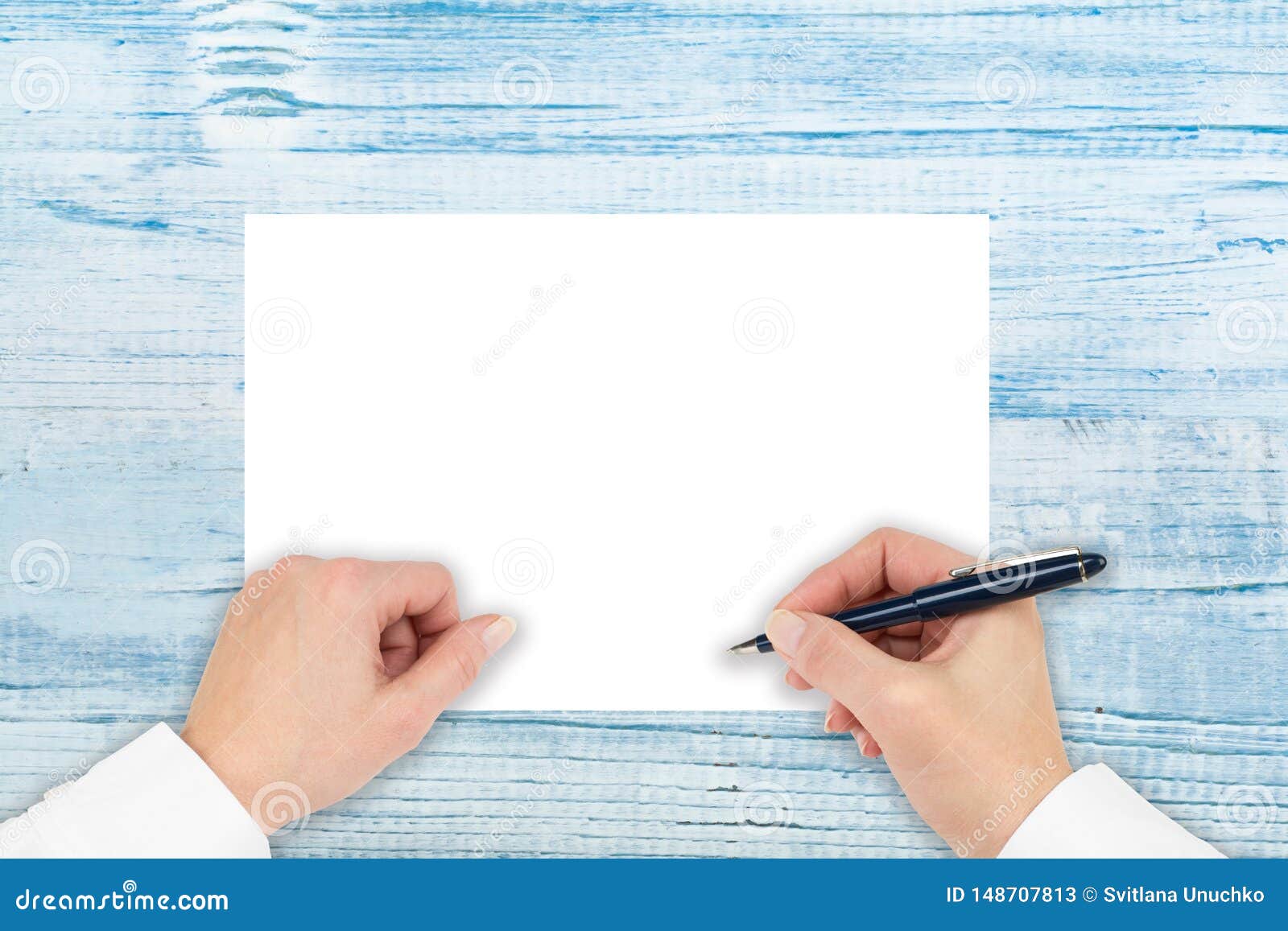 A Hand is Writing on a Paper on a Wooden Table. Make Notes, Make Plans ...