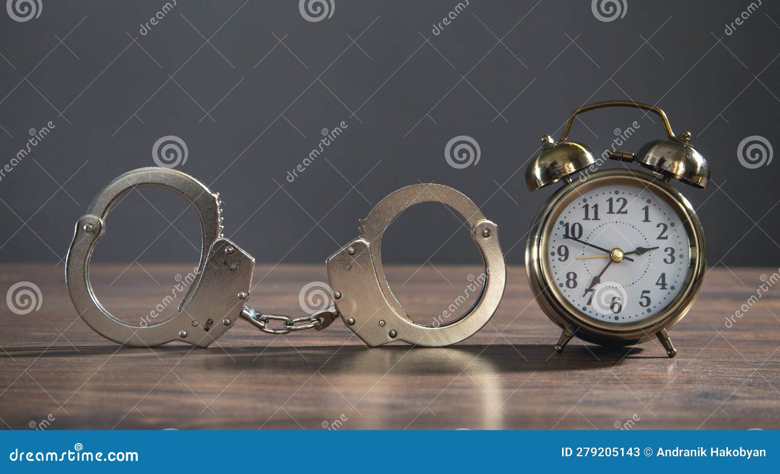 Handcuffs and Alarm Clock on the Wooden Background Stock Image - Image ...