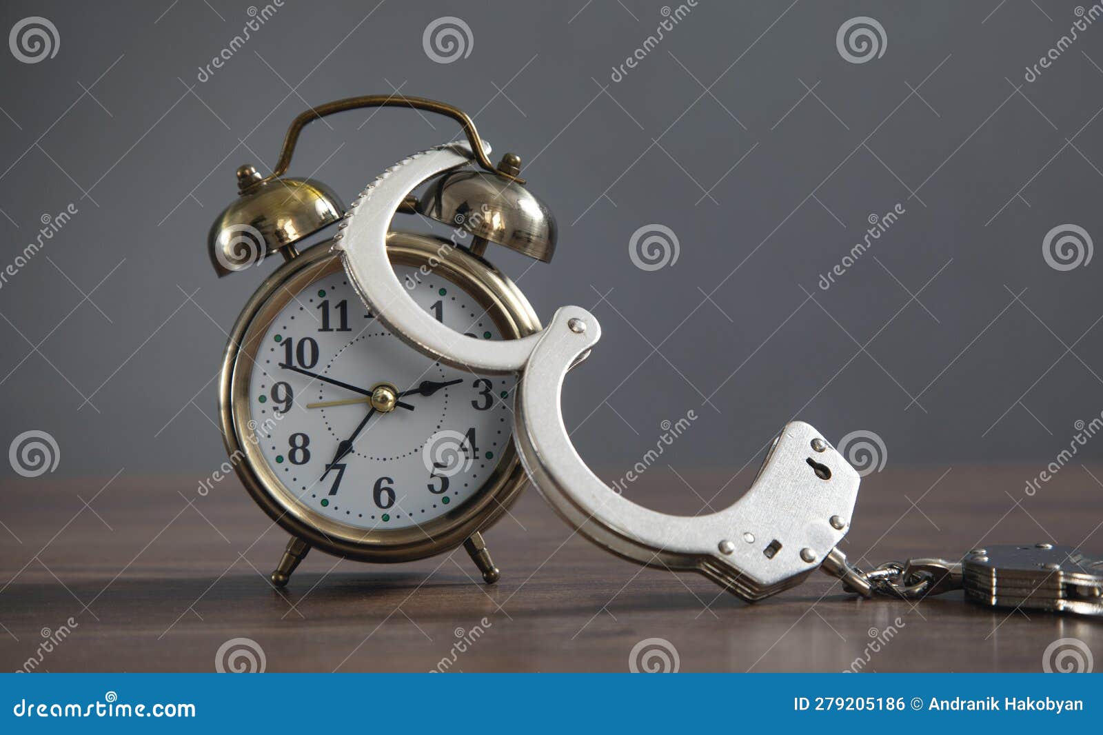 Handcuffs and Alarm Clock on the Wooden Background Stock Photo - Image ...