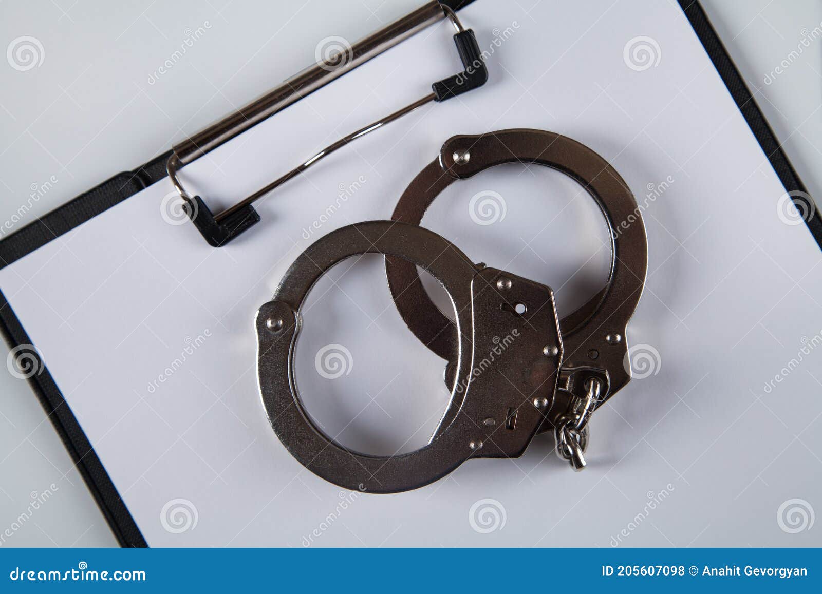 Handcuffs a Blank Sheet of Paper on the Table Stock Photo - Image of ...