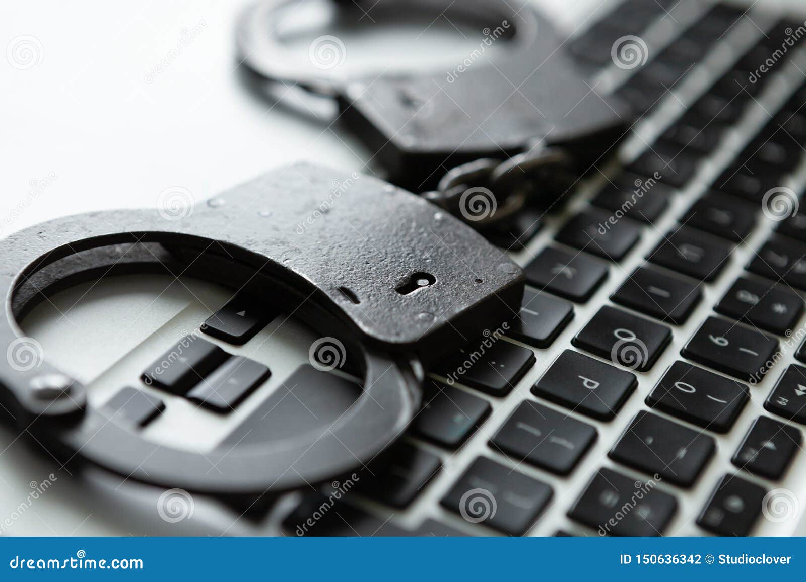 Handcuffs Over a Laptop - Close Up Studio Shot Stock Photo - Image of ...