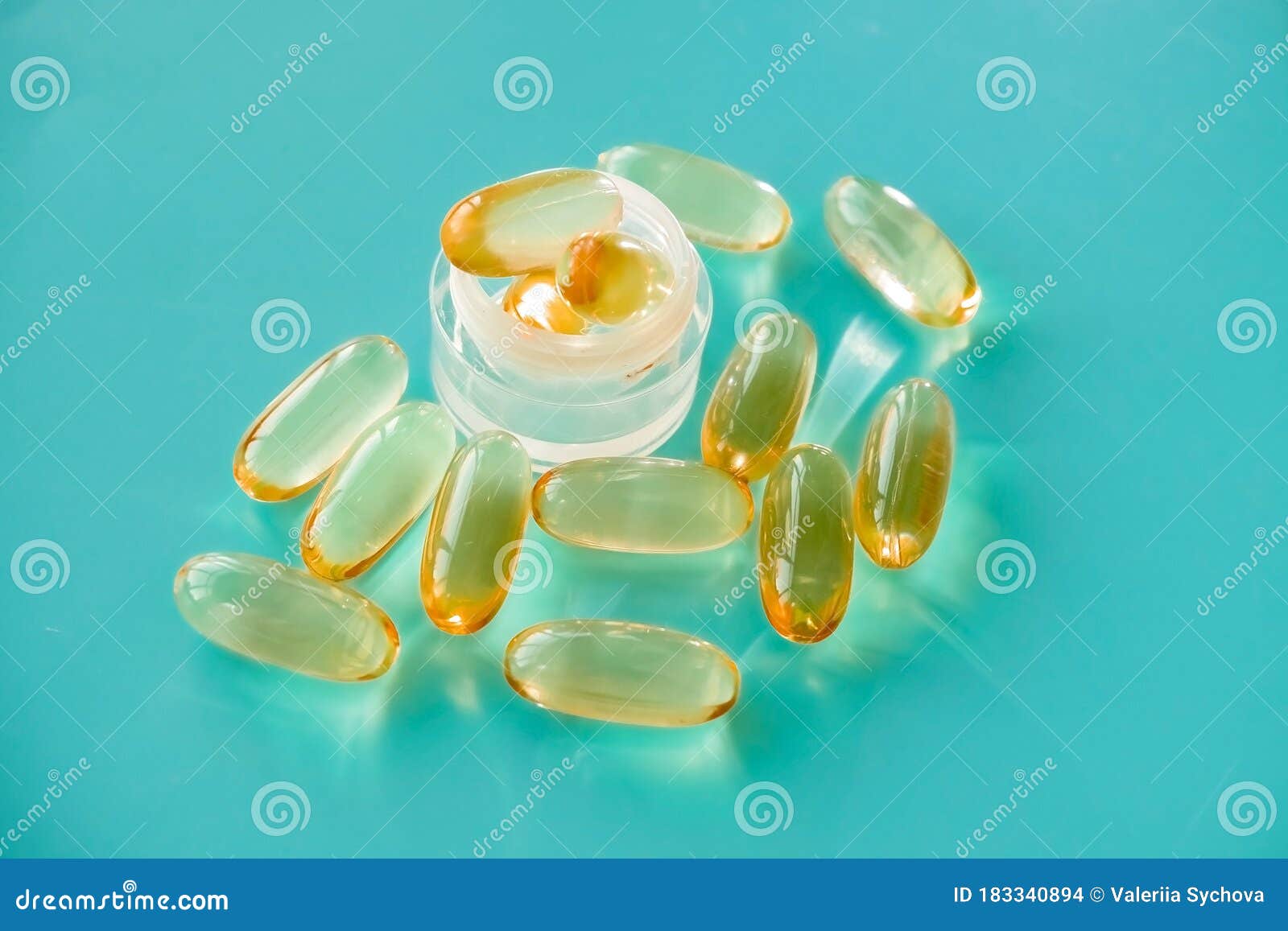 A Handful of Omega 3 Capsules with a Glass Beaker on a Blue Background ...