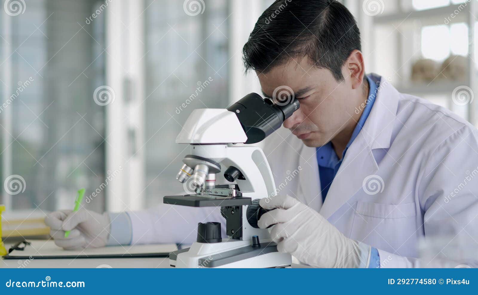 Young Scientist Man Looking through Microscope in Laboratory Stock ...
