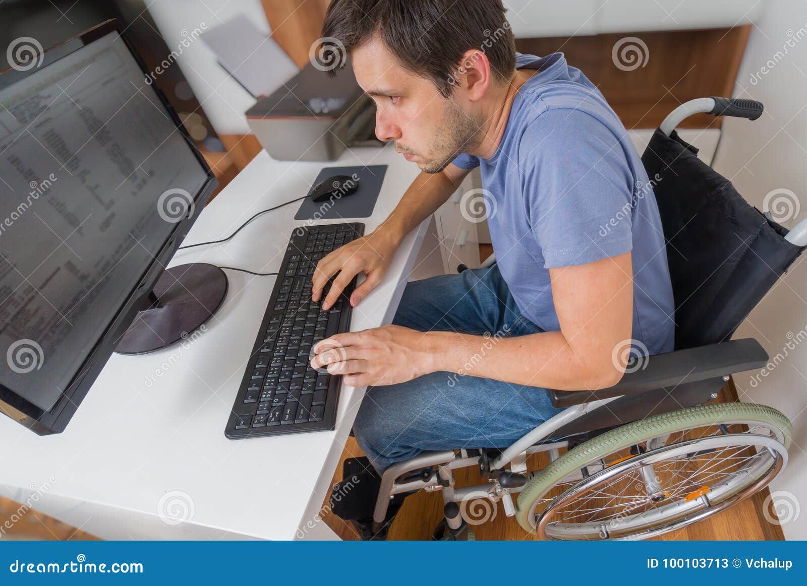 Handicapped Disabled Man On Wheelchair Is Working With Computer In