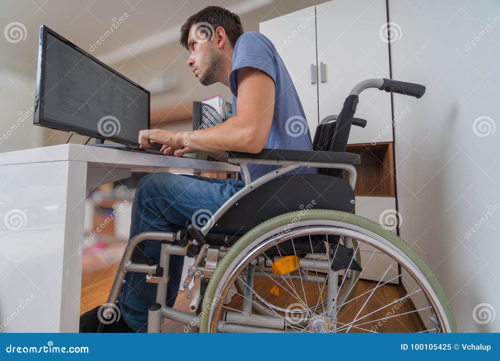 Handicapped Disabled Man On Wheelchair Is Working With Computer In