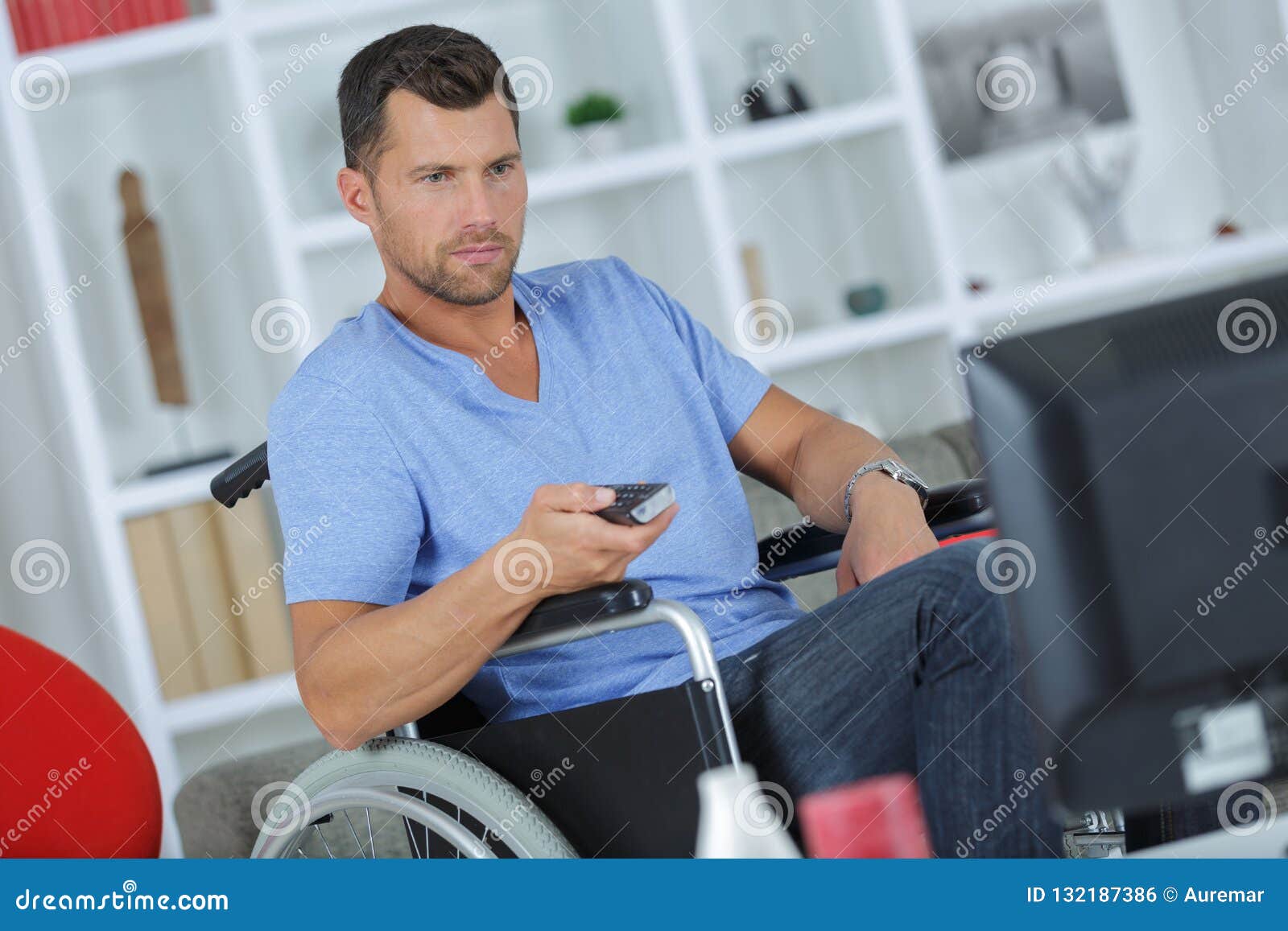 Handicapped Man Using Remote Control while Watching Television Stock ...