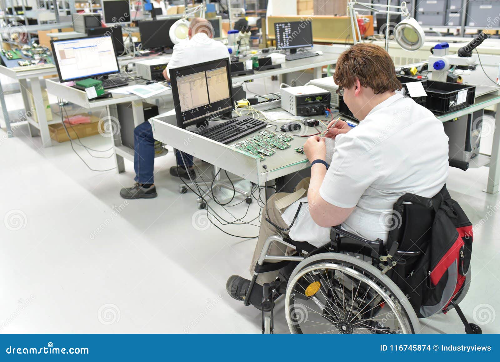 Handicapped Worker in a Wheelchair Assembling Electronic Compone ...