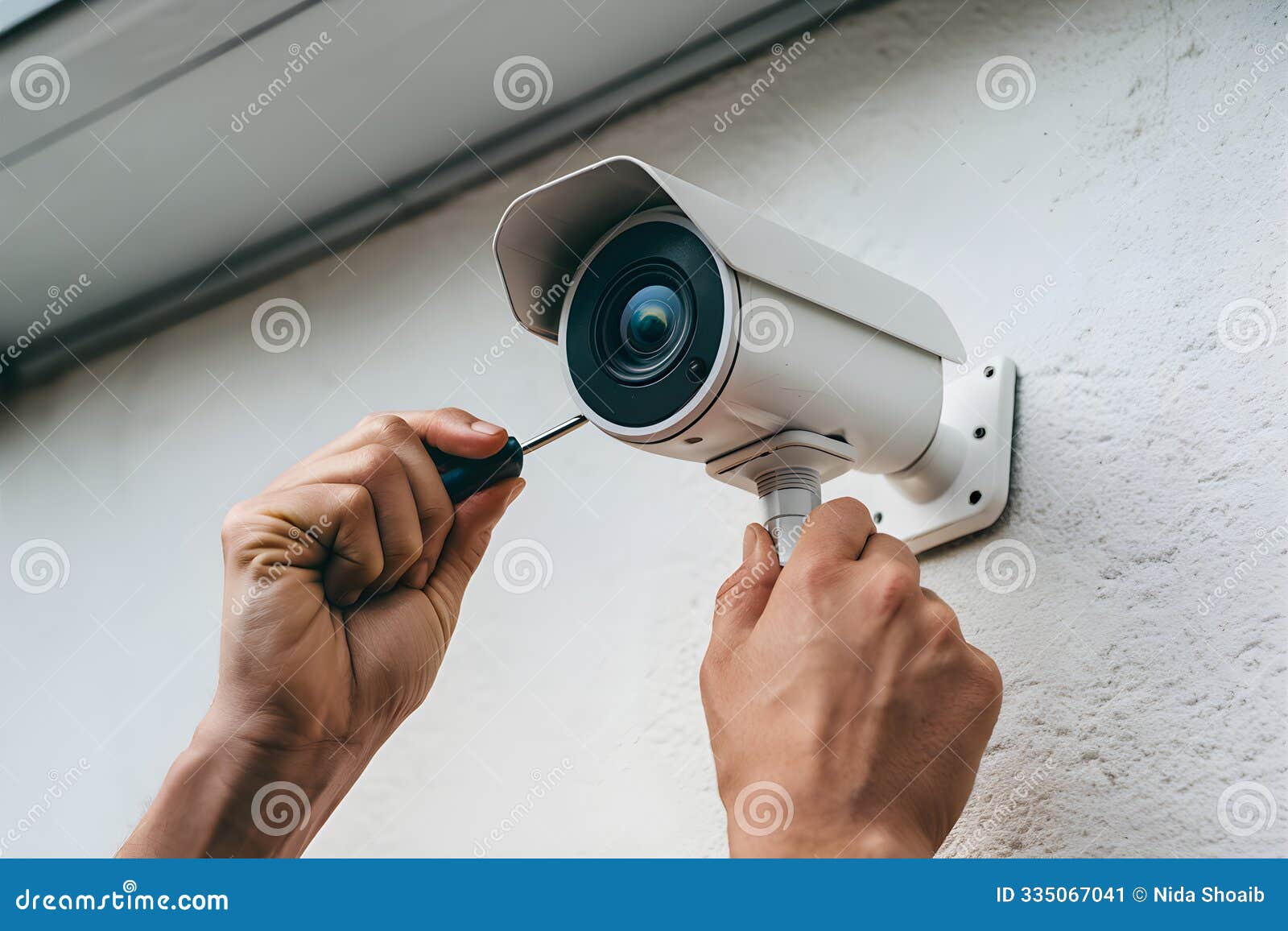 Hands Adjusting White Security Camera on Wall with Tool, Securing ...