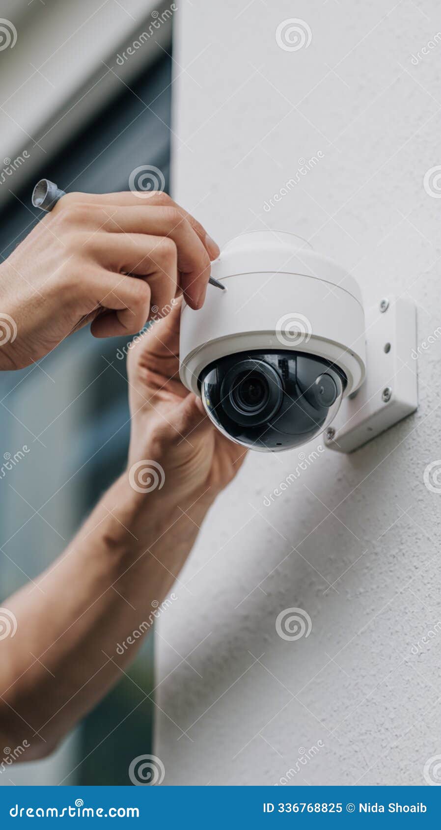 Hands Adjusting White Security Camera on Wall with Tool, Securing ...