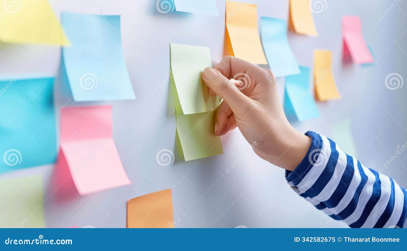 Hands Arrange Soft Pastel Sticky Notes on a Chart, Symbolizing ...