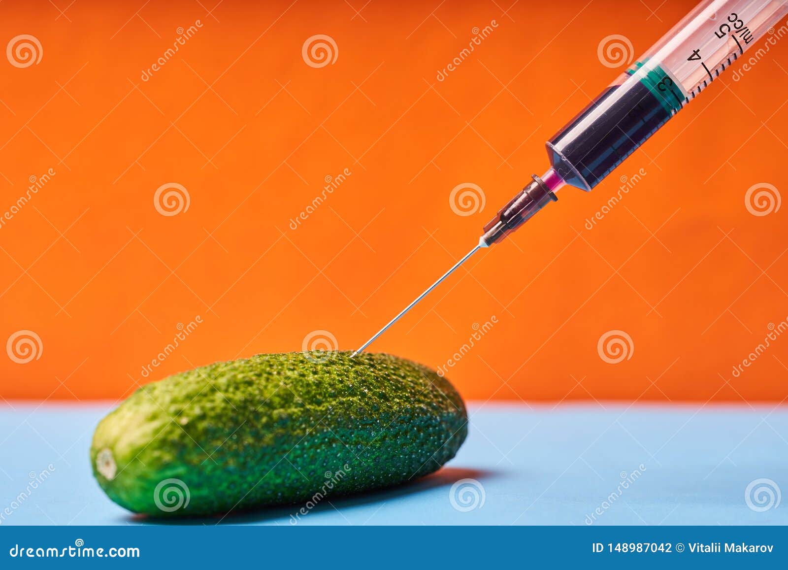 Hands in Blue Gloves Inject Liquid from Syringe into Cucumber ...