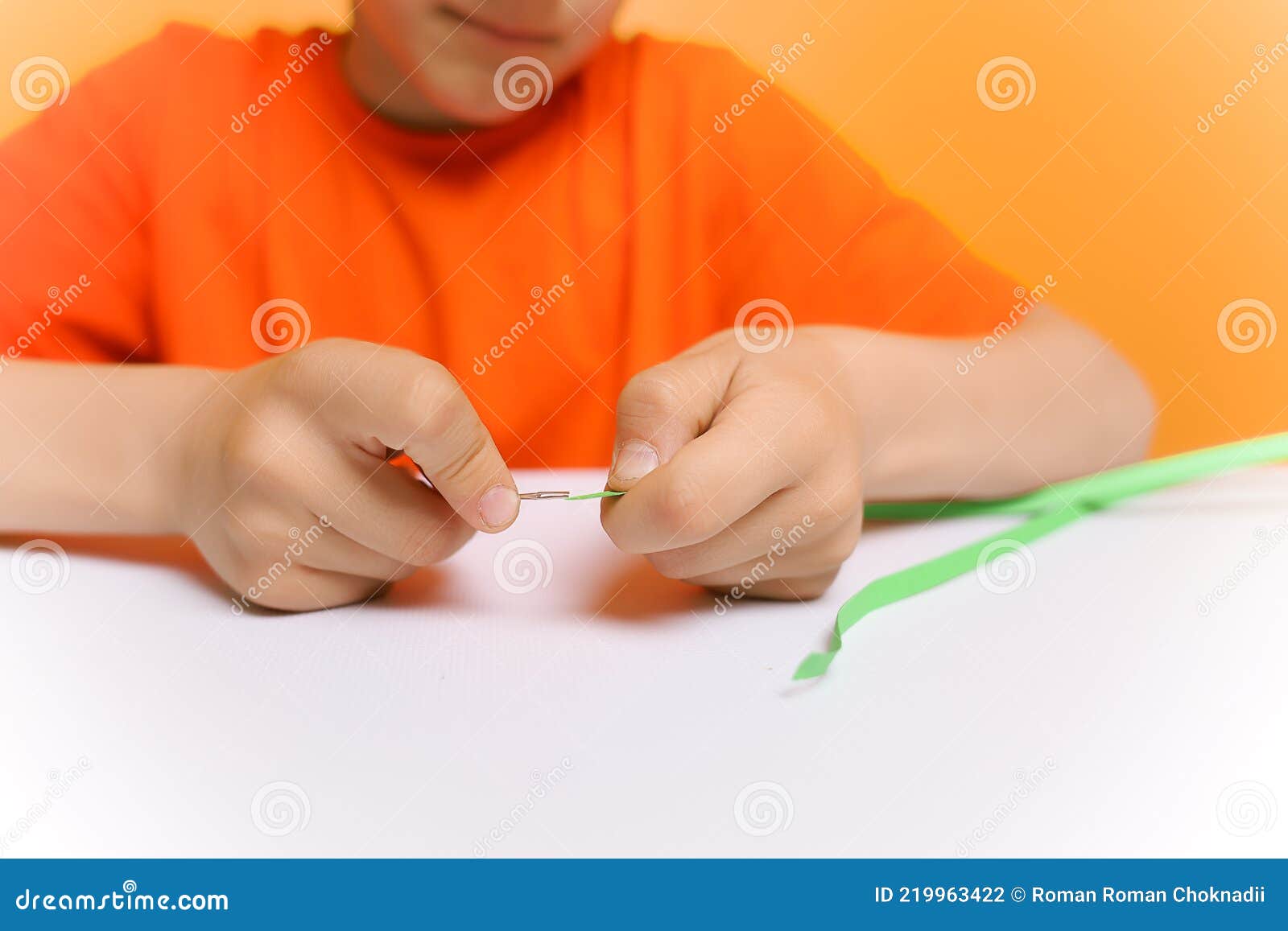 Hands of a Boy in Close Up Who Inserts Thin Paper Strips into a ...