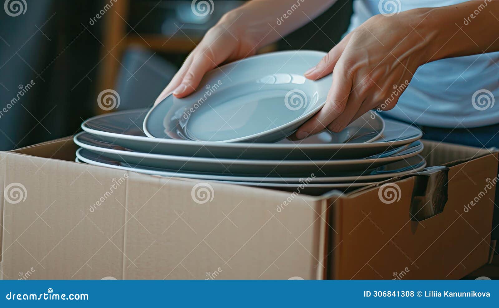 Hands Carefully Stacking Plates into a Cardboard Moving Box ...
