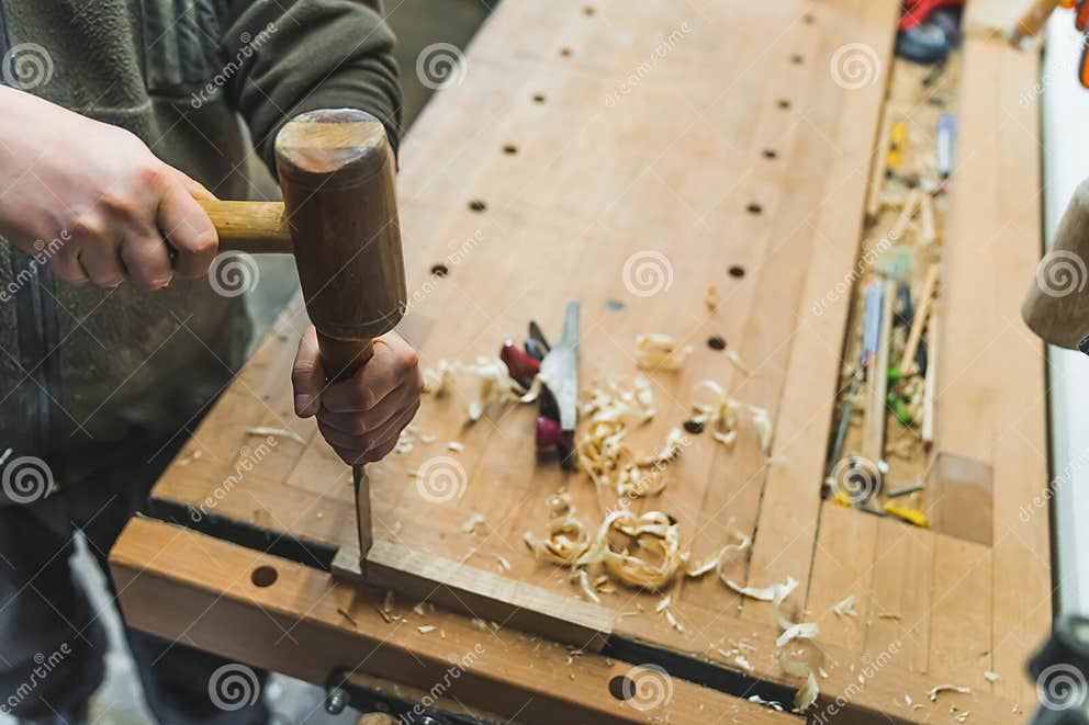 Hands of a Carpenter Using a Chisel and Hammer To Carve Wood on the ...