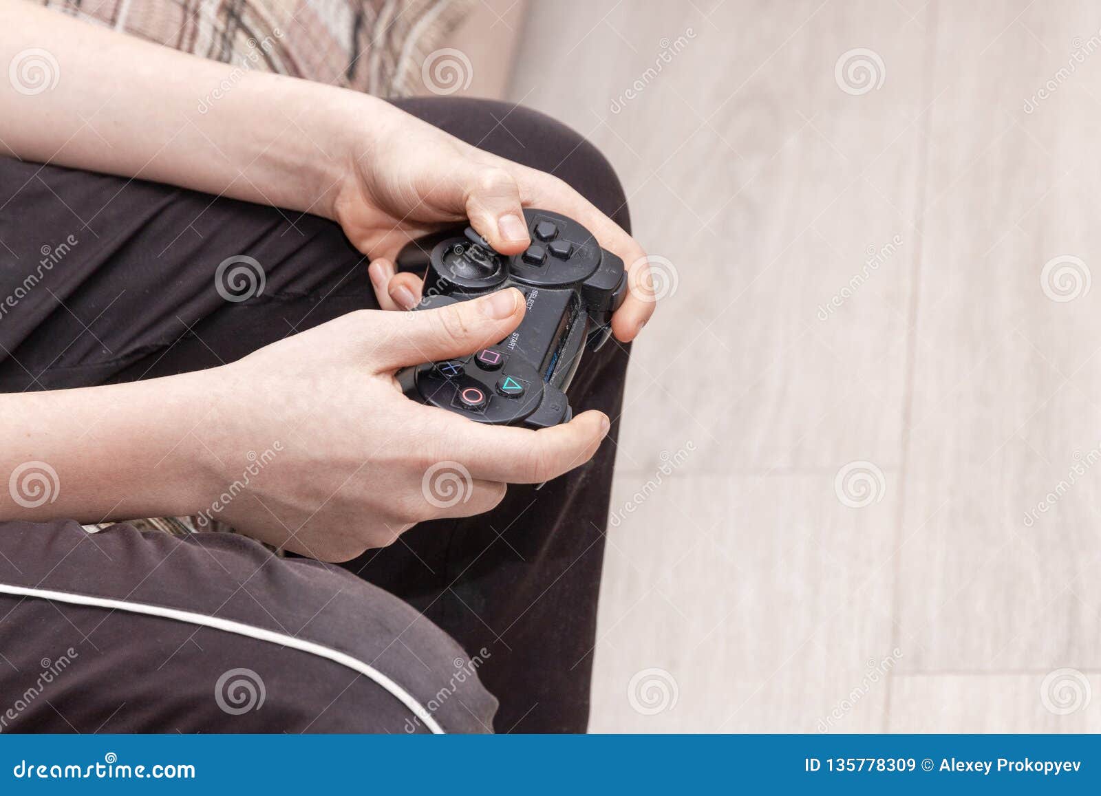 Hands of a Caucasian Kid Holding a Black Console Pad Controller ...