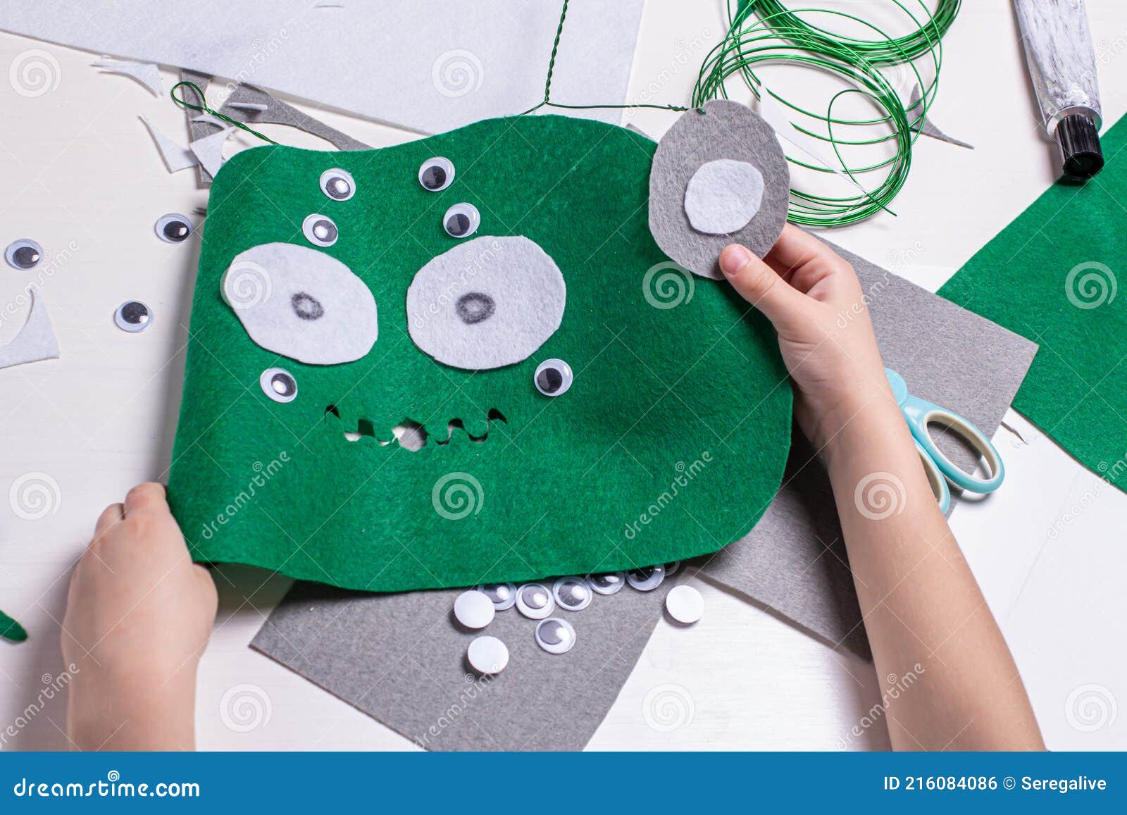 Hands of a Child Doing Homework on Making an Alien Mask. Craft Tools ...