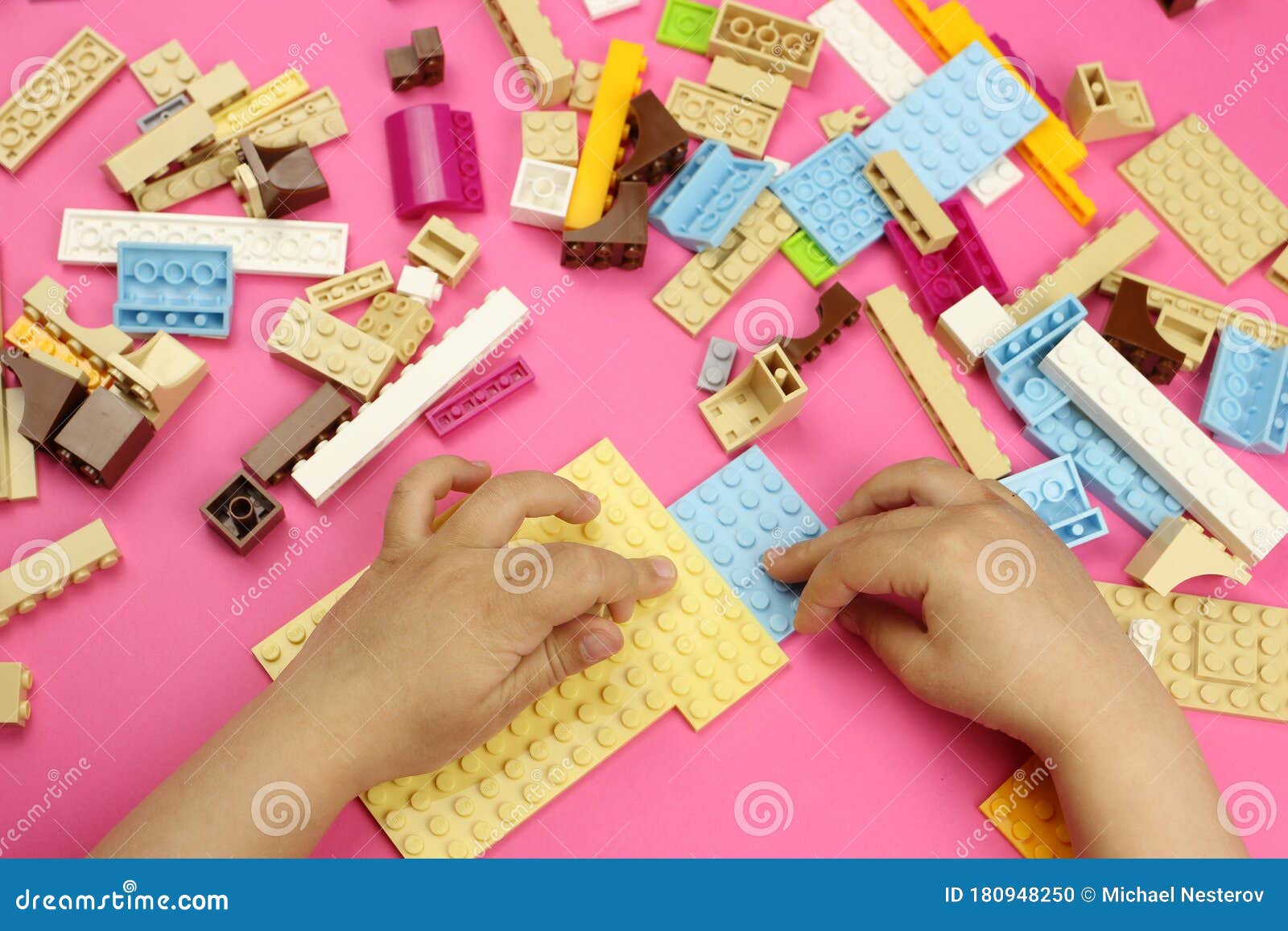 Hands of a Child Playing with Colored Blocks, Bricks on a Pink ...