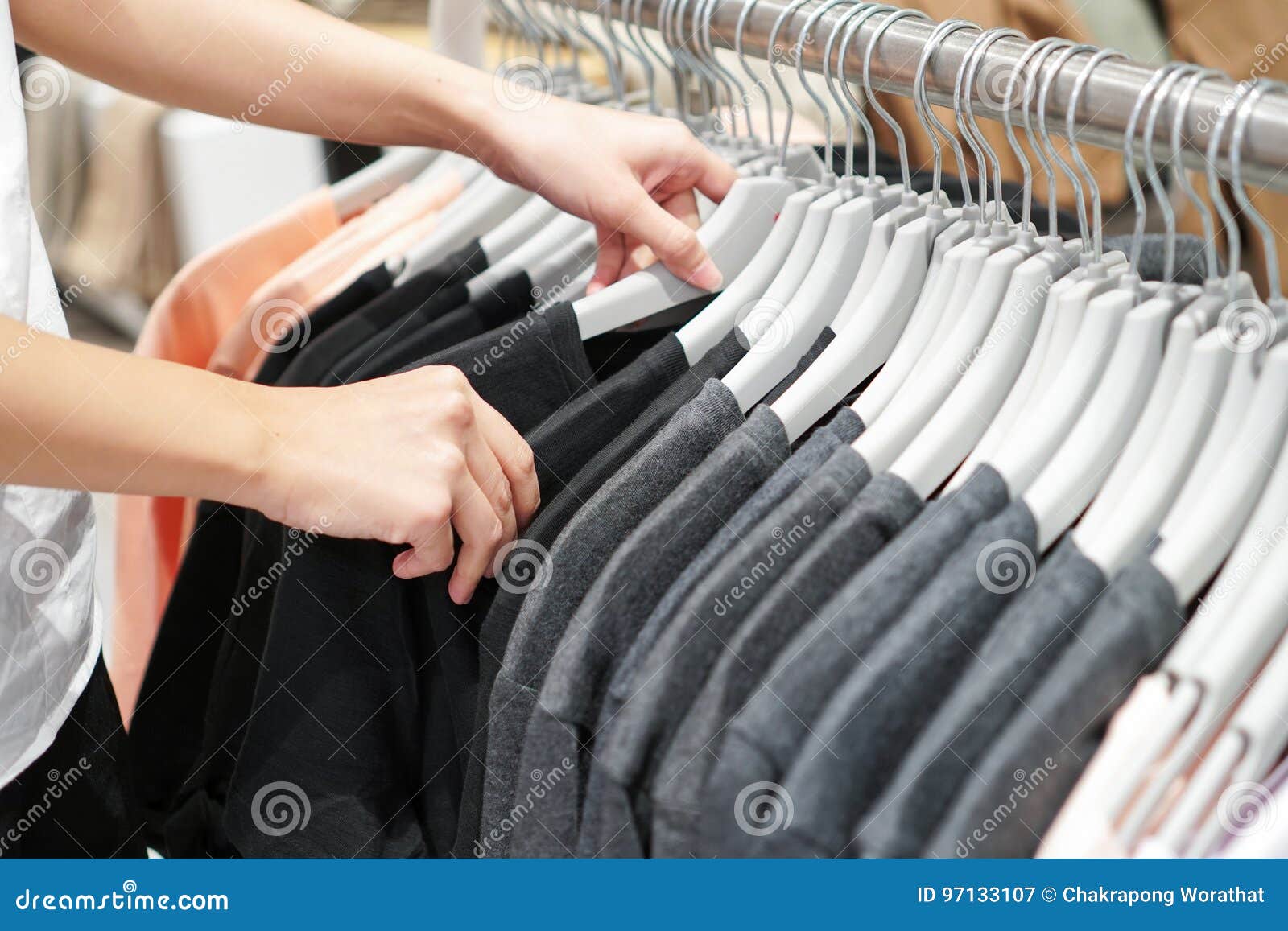 Hands Choosing Clothes on a Rack in a Showroom. Stock Image - Image of ...