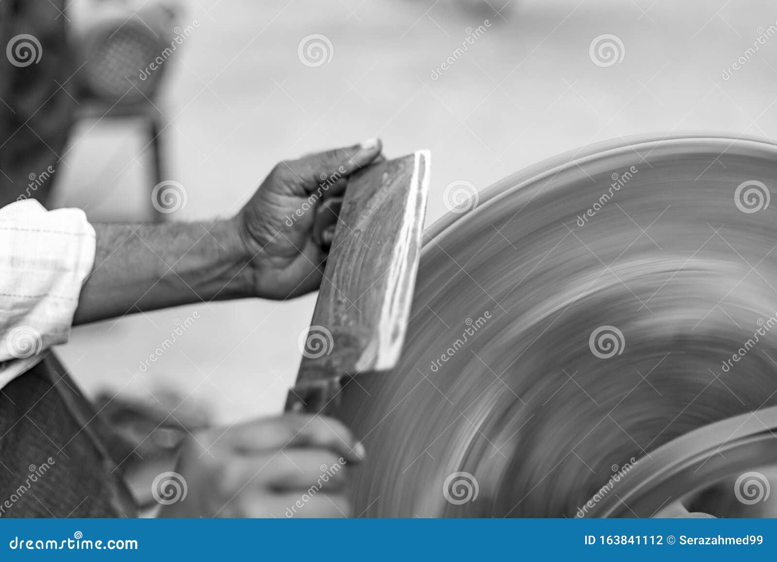 Hands of Construction Worker Sharpens a Knife on Sanding Machine Stock ...