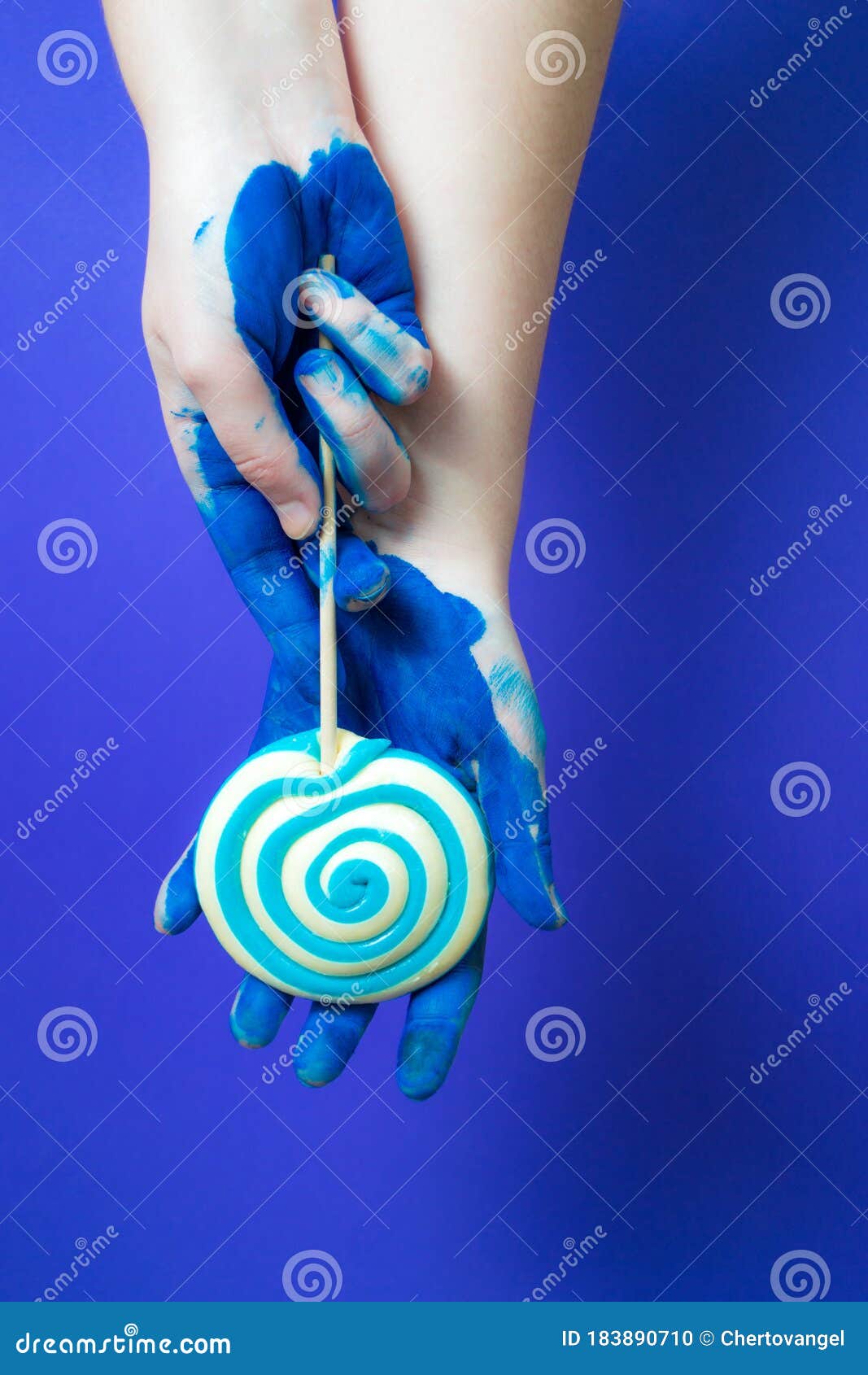 Hands Covered by Blue Paint Hold Lollipop on Blue Background Stock ...
