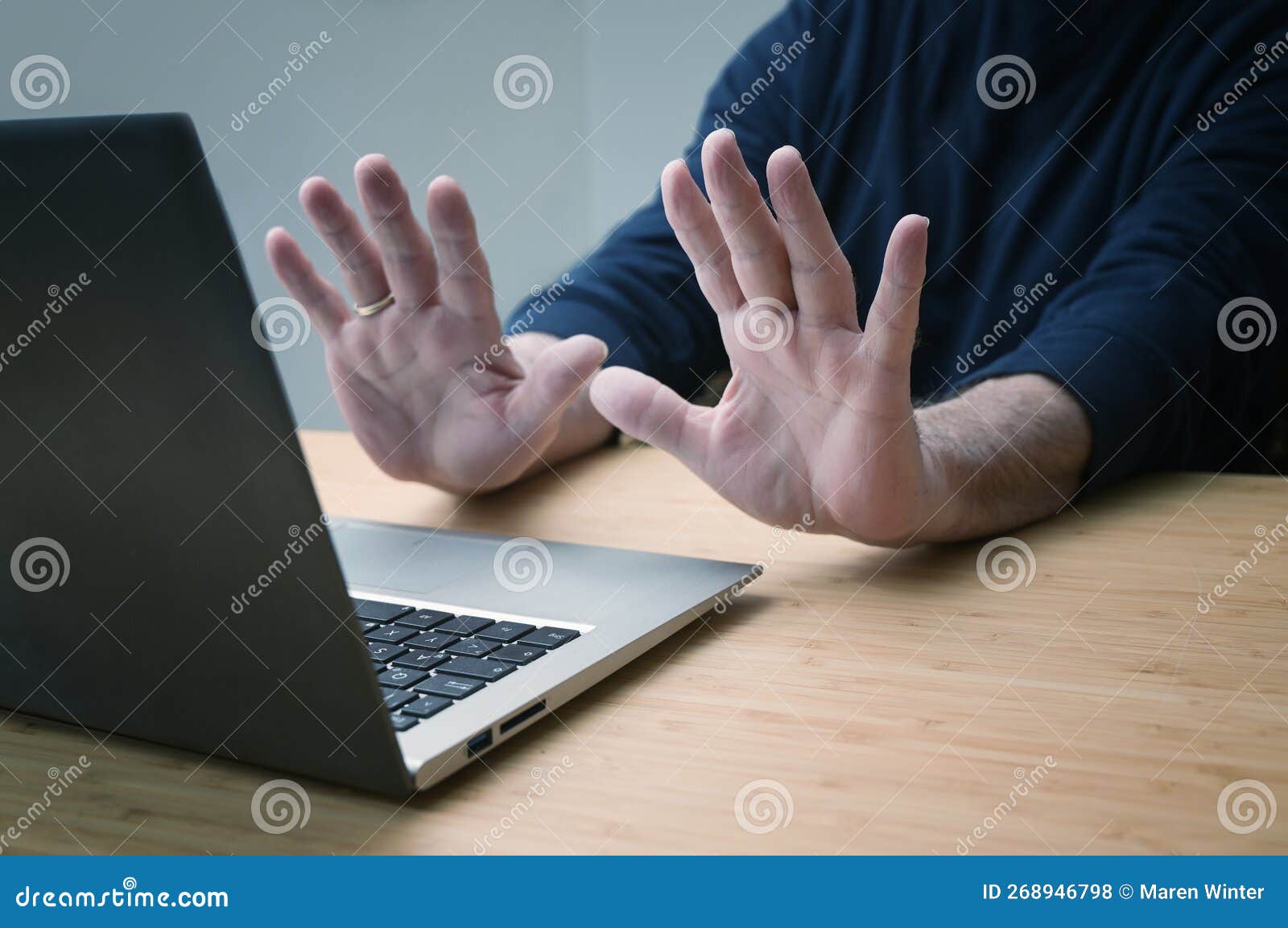 Hands in Defensive Gesture Against a Laptop Computer, Avoiding Further ...
