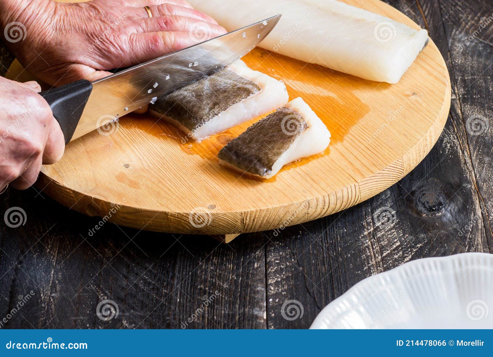 Hands of Elderly Woman Cutting a Cod Fillet with Knife on Cutting Board ...