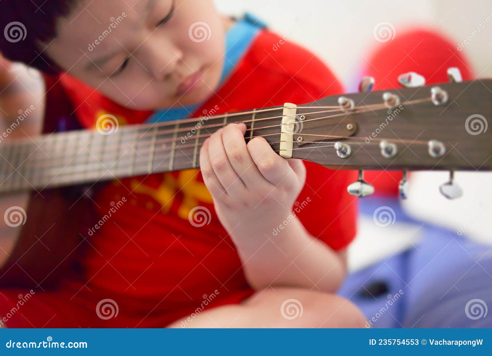 Hands and Fingers Grasping Chords, Playing the Guitar. the Boy Looked ...