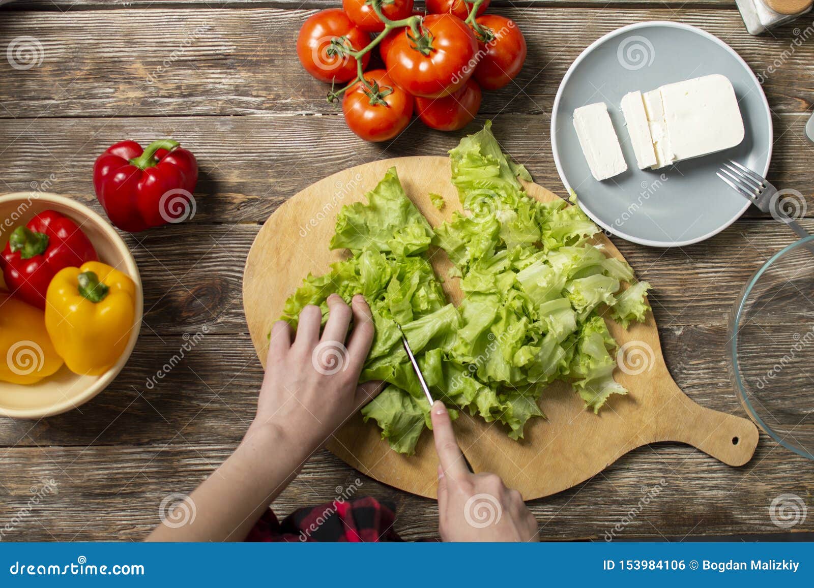 Hands Of The Girl Cut Lettuce On A Table A Woman Prepares A Veggie
